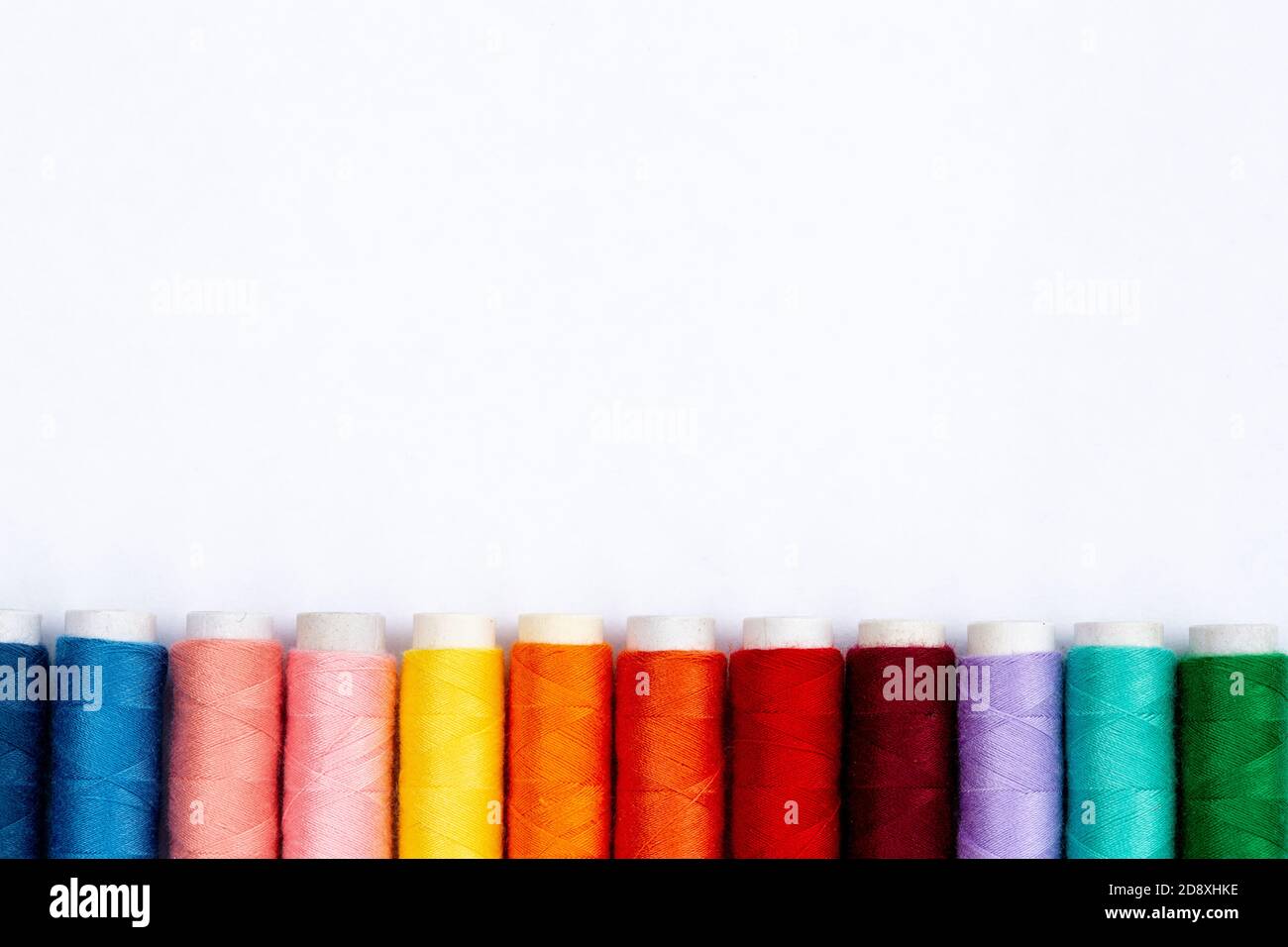 Colorful sewing threads on white background, top view. Spools of thread ...