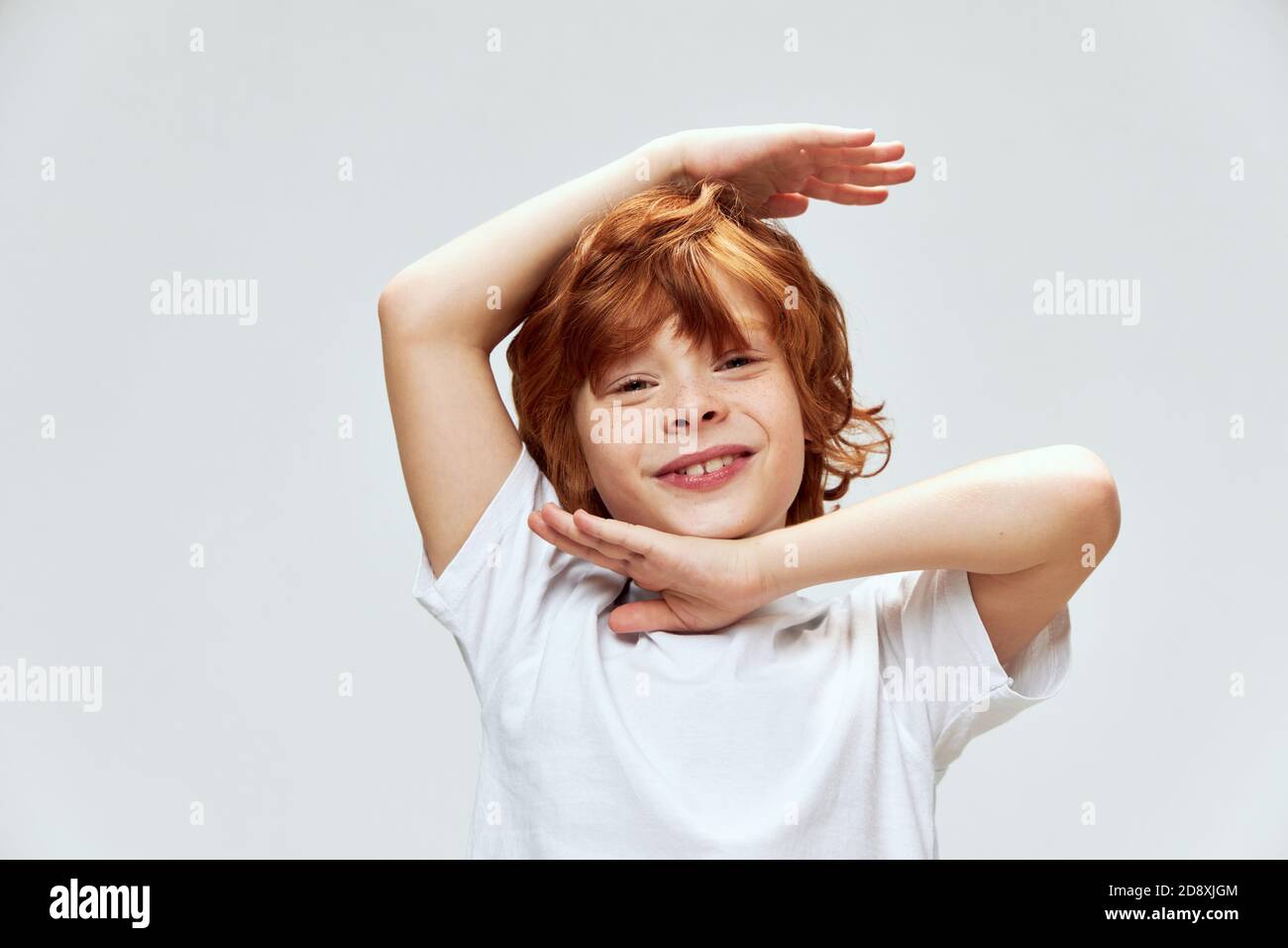 Grimacing boy holding hands above head smile cropped view Stock Photo ...