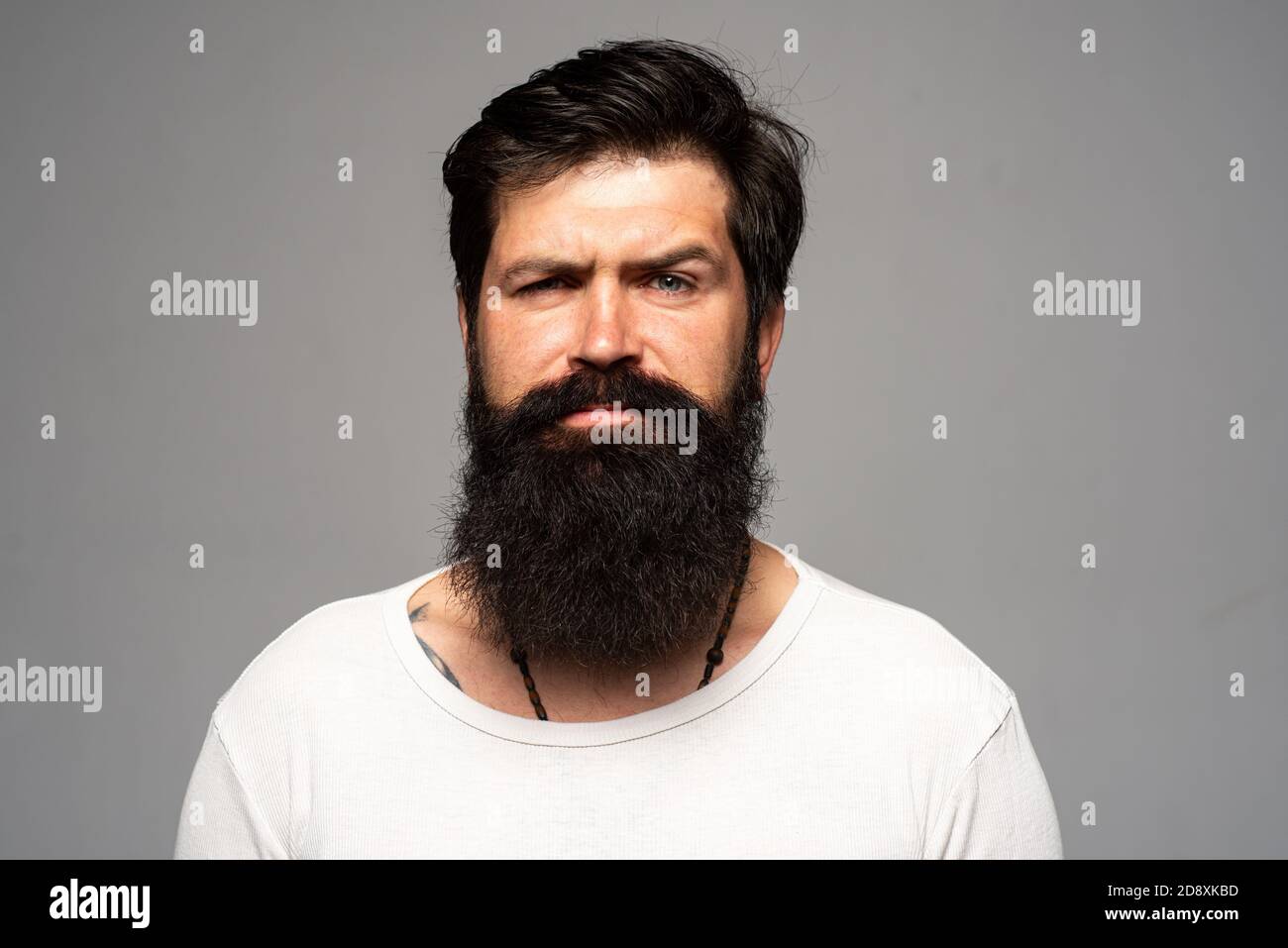 Portrait of confident serious man has beard and mustache, looks seriously, isolated. Hipster guy ...