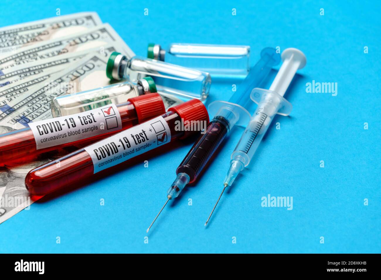 Close up 100 US dollar bills, vaccine ampoules and blood sample in test ...