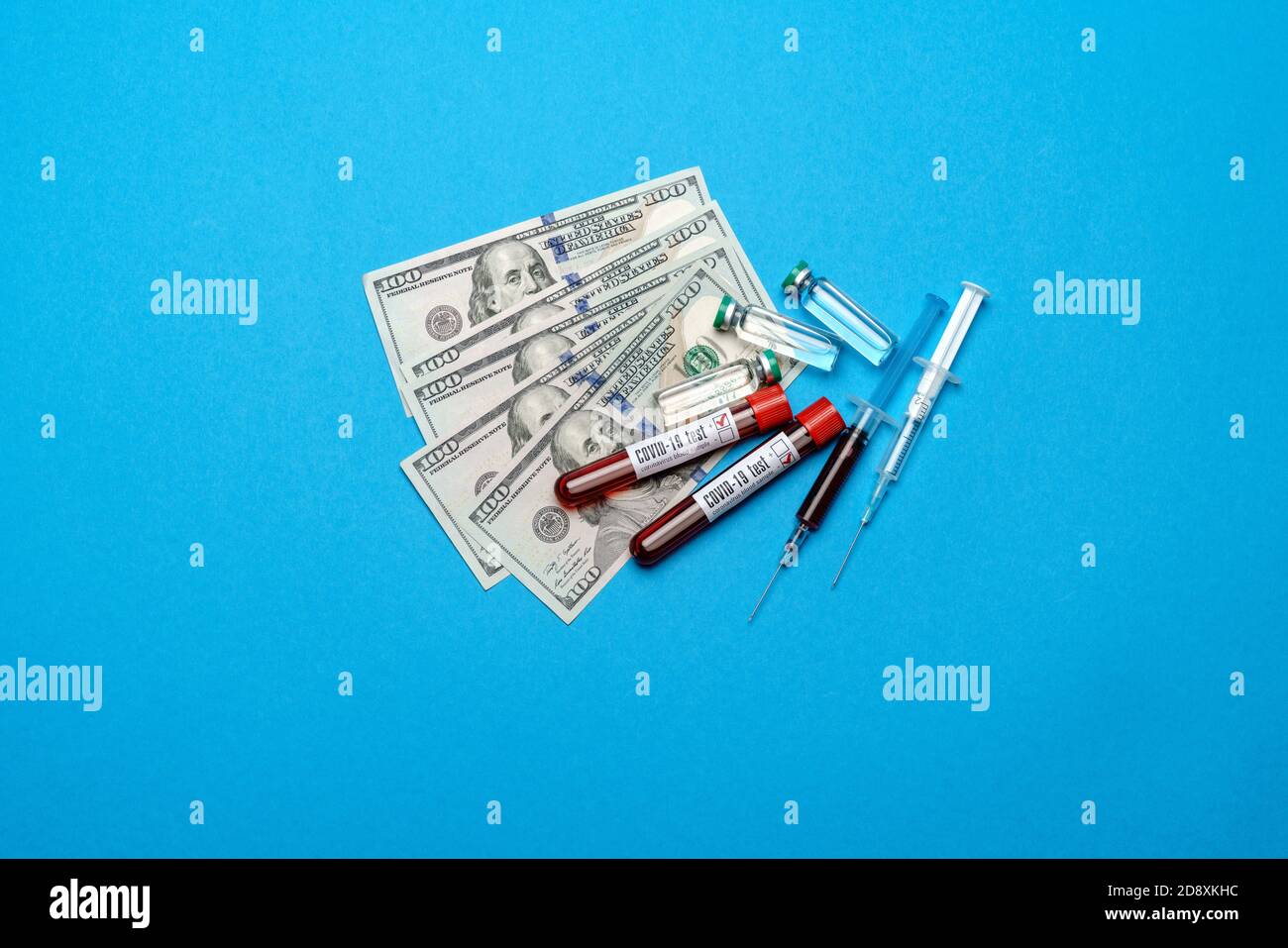 Close up 100 US dollar bills, vaccine ampoules and blood sample in test ...