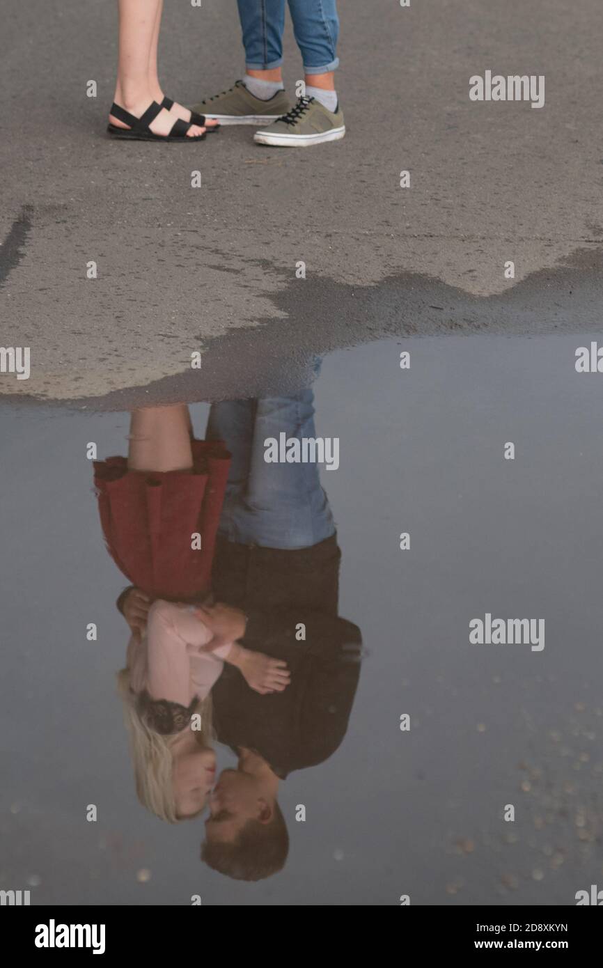 Young couple in love kissing reflected in puddle Stock Photo - Alamy