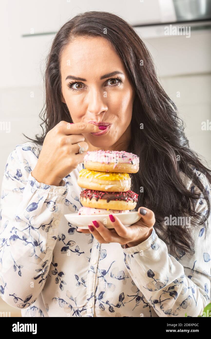 Female tasting donuts from a selection on a plate in front of her Stock ...