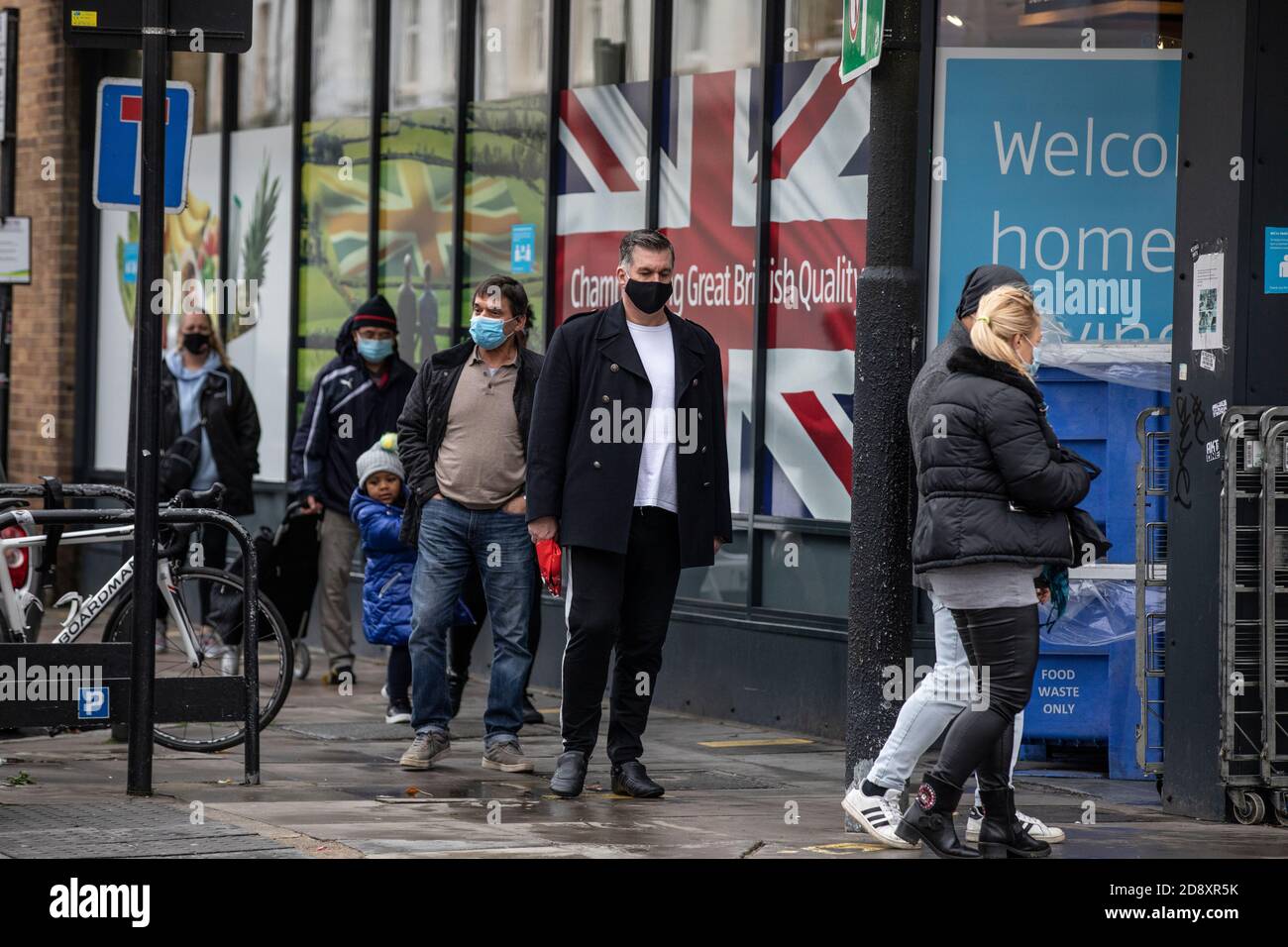 Shoppers queue outside an ALDI Local supermarket to pick up household ...