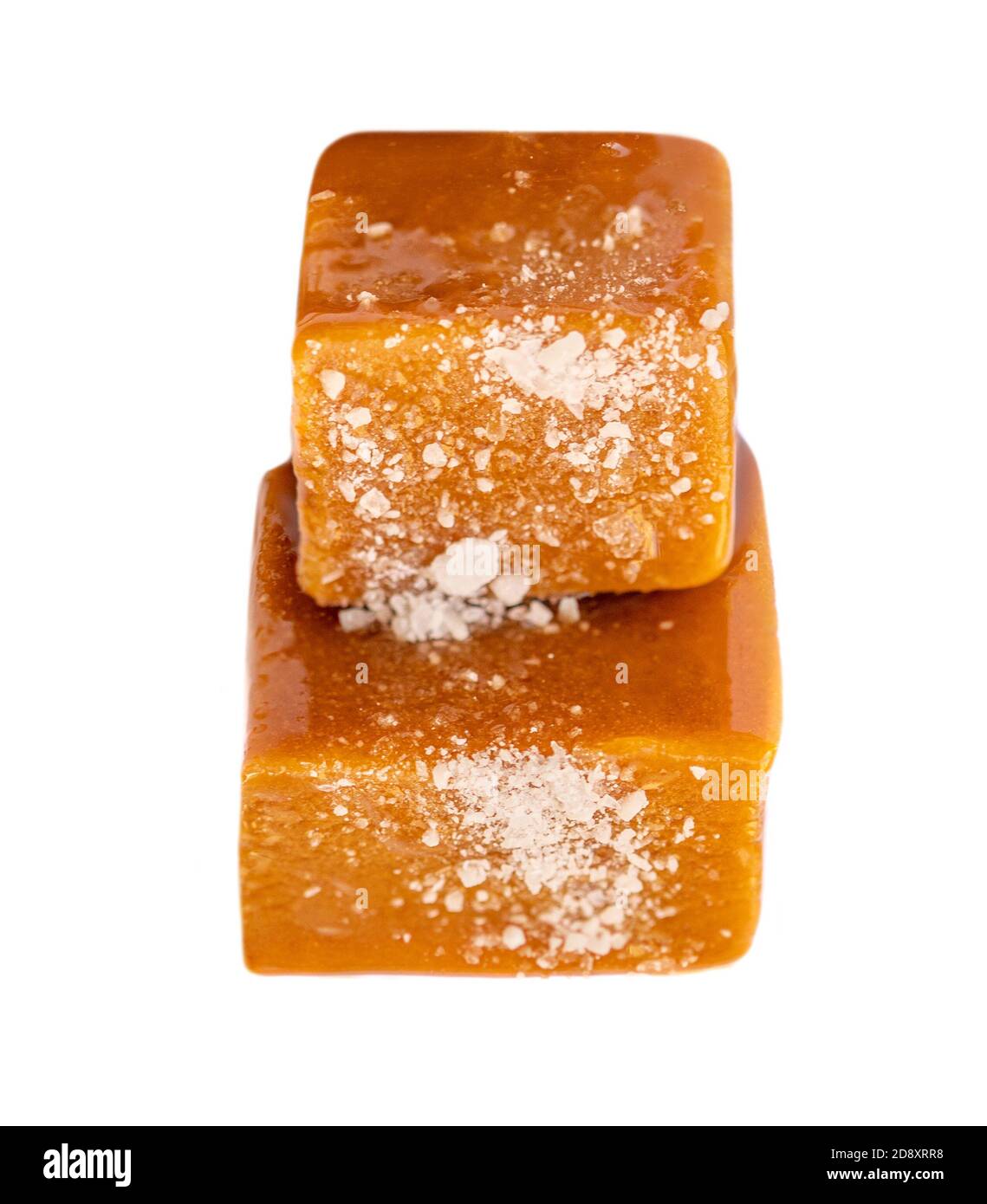 Caramel candies and sweet sauce isolated on white background, top view ...