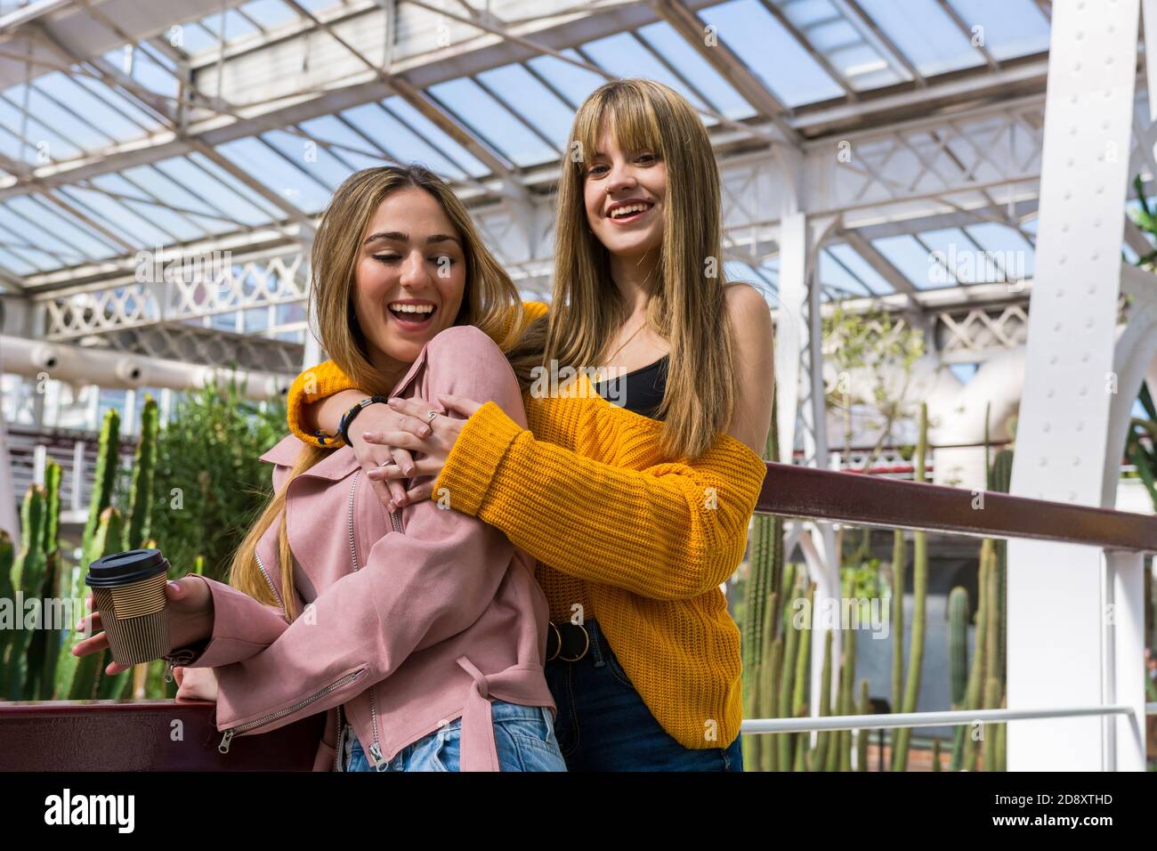 Two happy friends hug each other on the street as they walk and have a ...