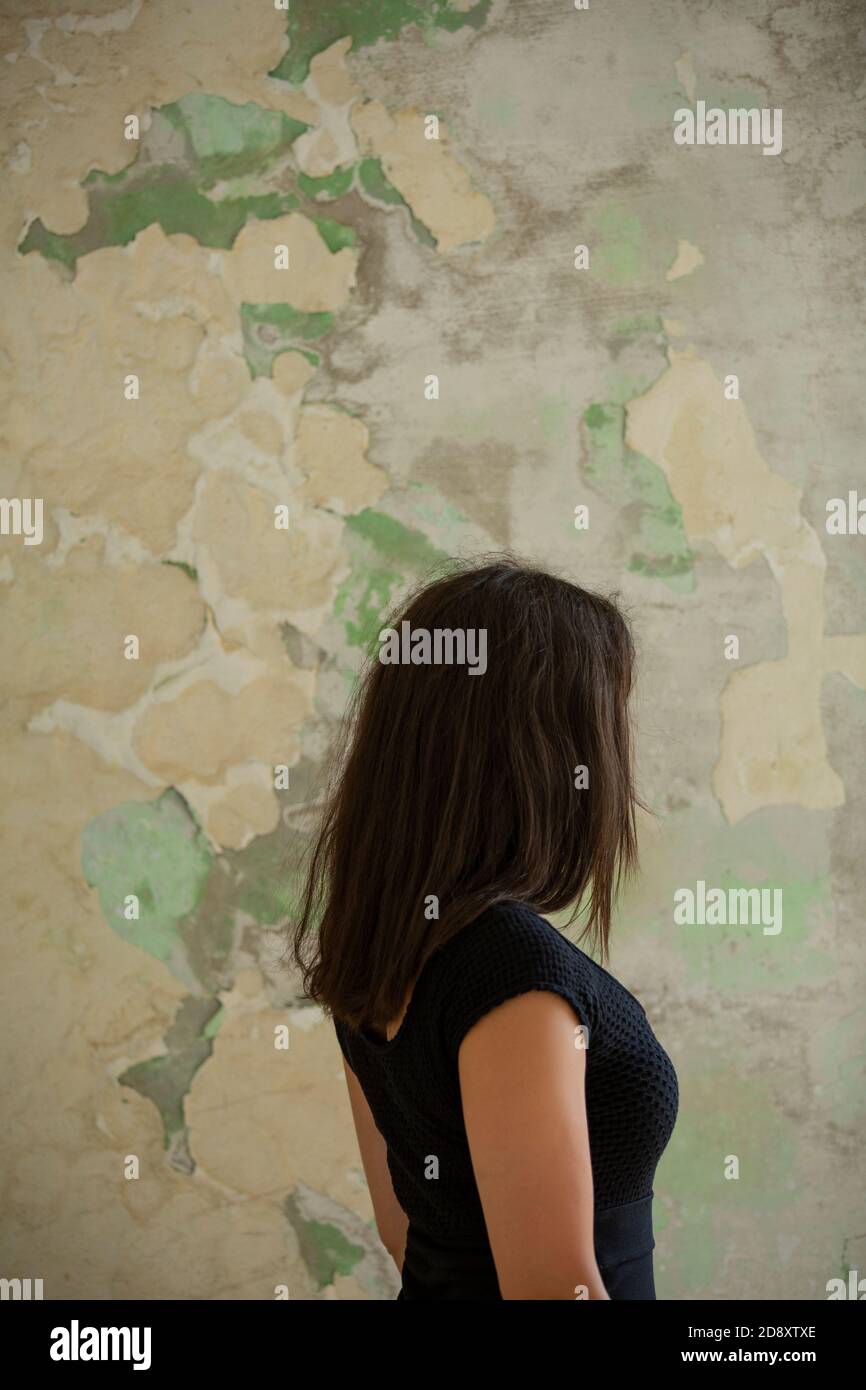 Side view of woman inside derelict building Stock Photo - Alamy