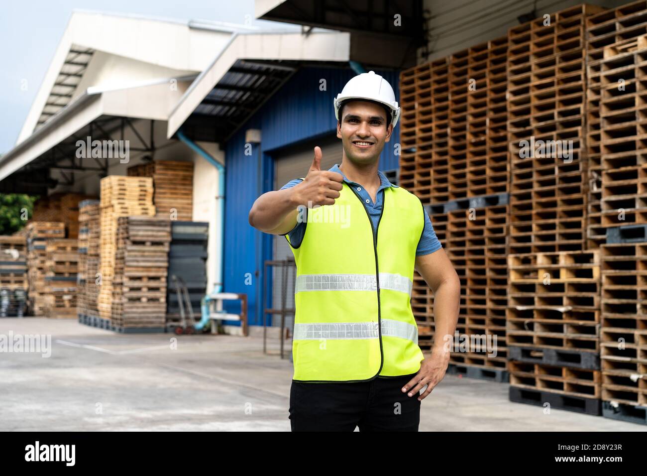 Portrait of young Indian worker working in logistic industry outdoor in ...