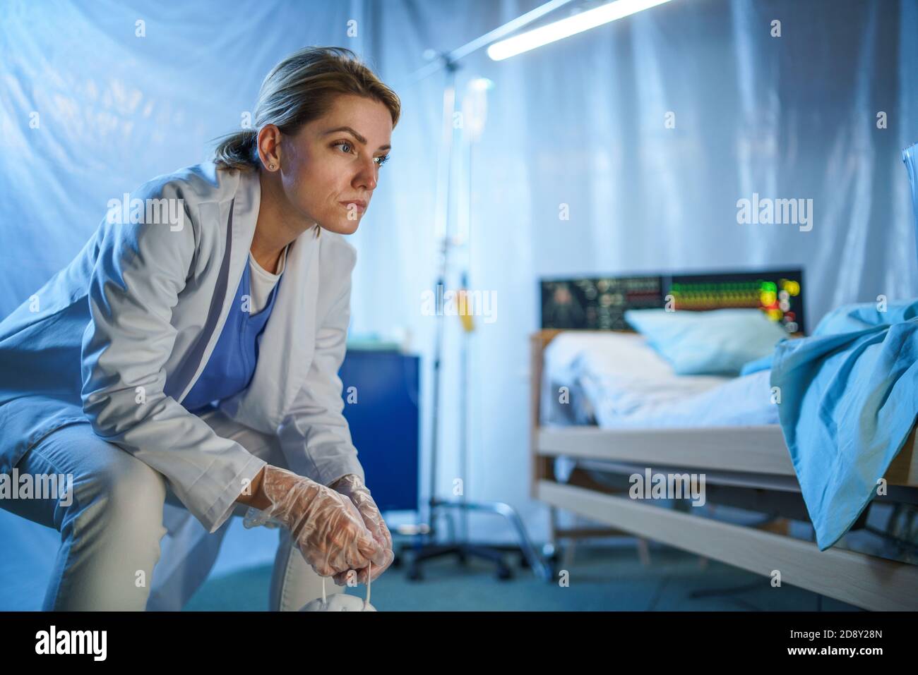 Tired and frustrated doctor by empty bed in hospital, coronavirus ...
