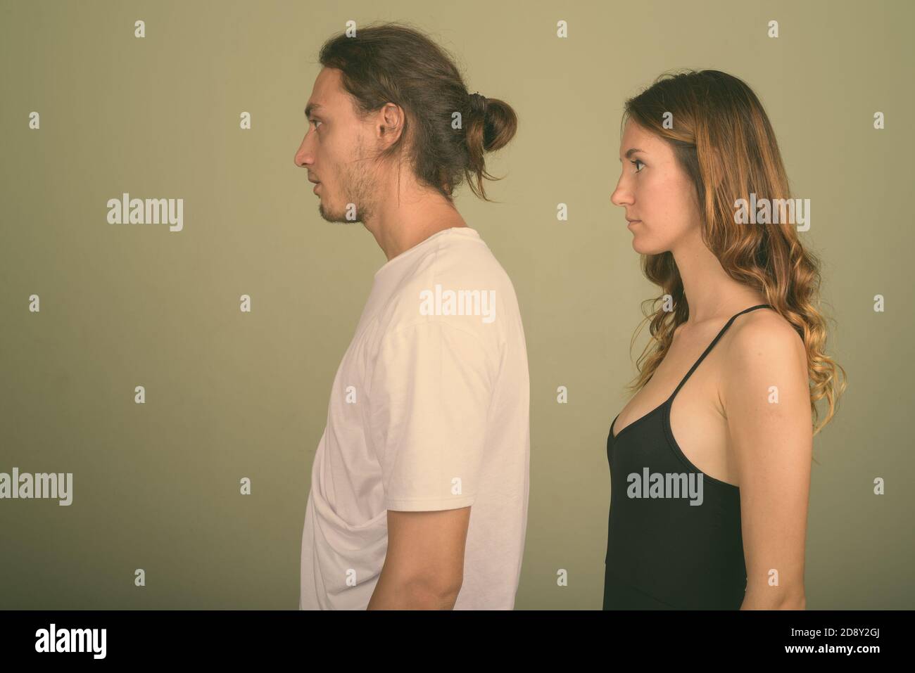Young handsome man and young beautiful woman together against colored ...