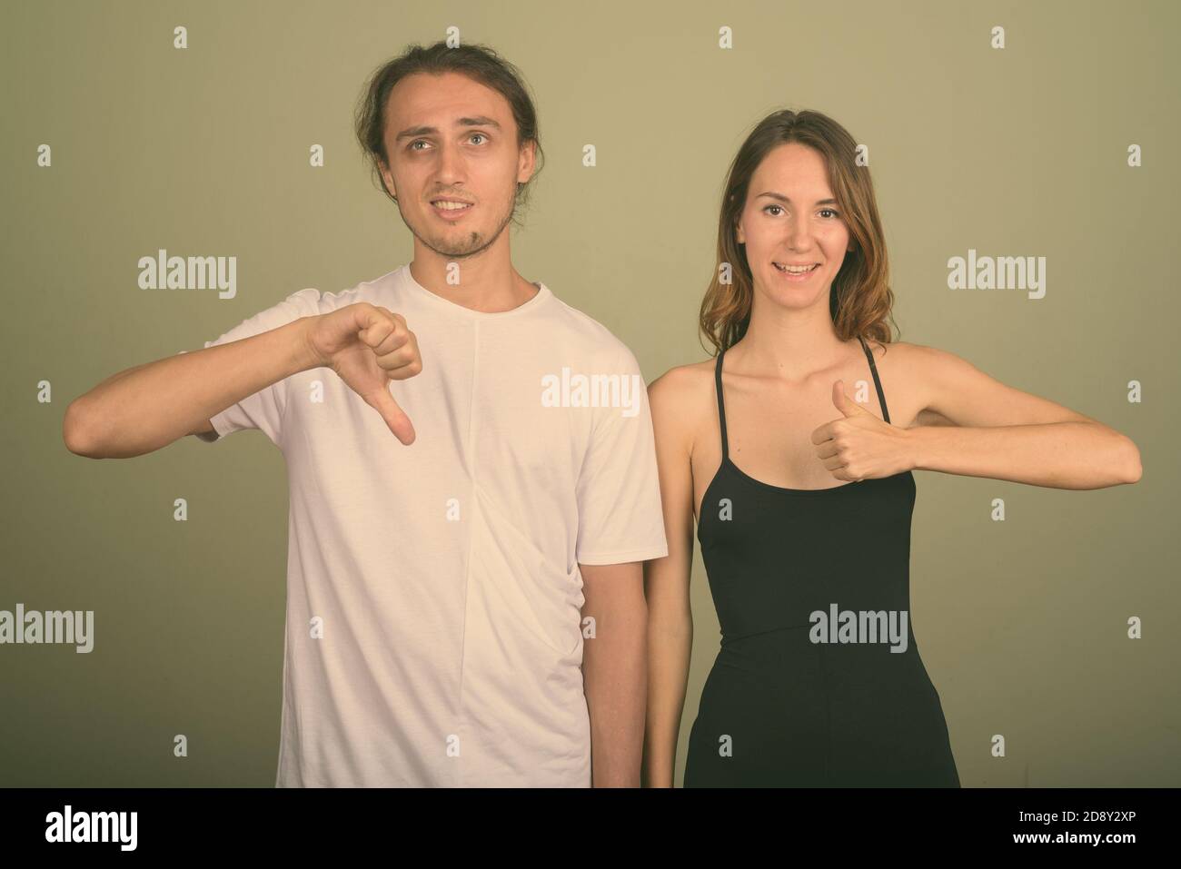 Young handsome man and young beautiful woman together against colored ...