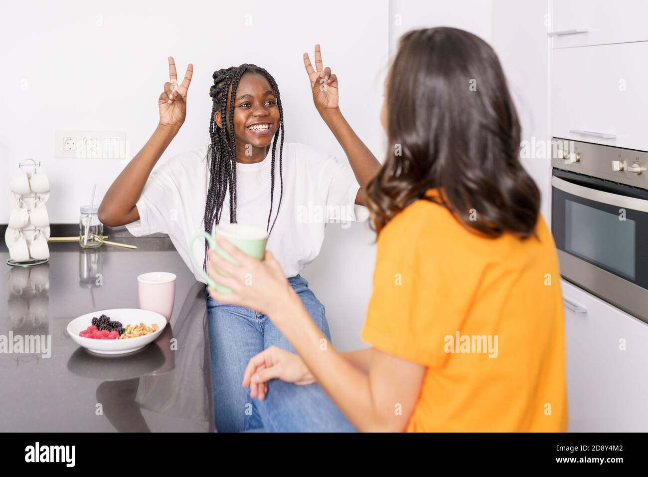 Two friends having a healthy snack while chatting at home Stock Photo ...