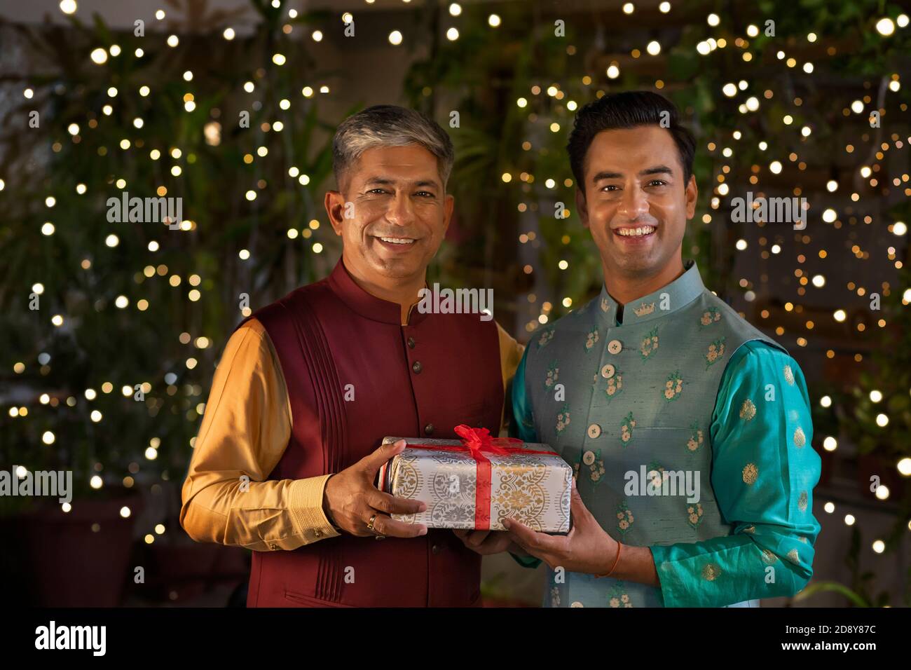A YOUNG MAN AND FATHER HAPPILY STANDING WITH DIWALI GIFT Stock Photo ...
