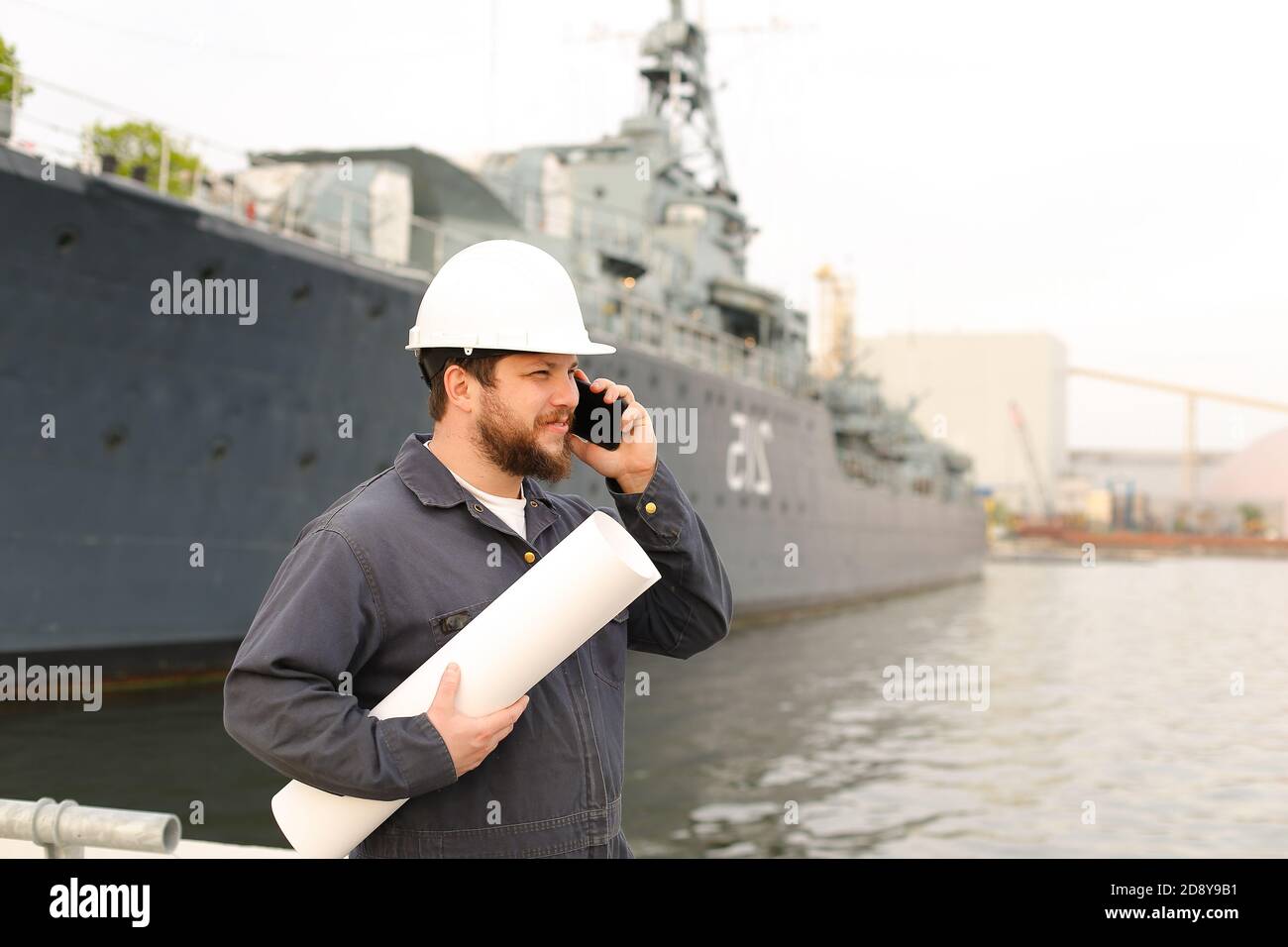 Marine male deckhand talking by VHF walkie talkie, holding papers near ...