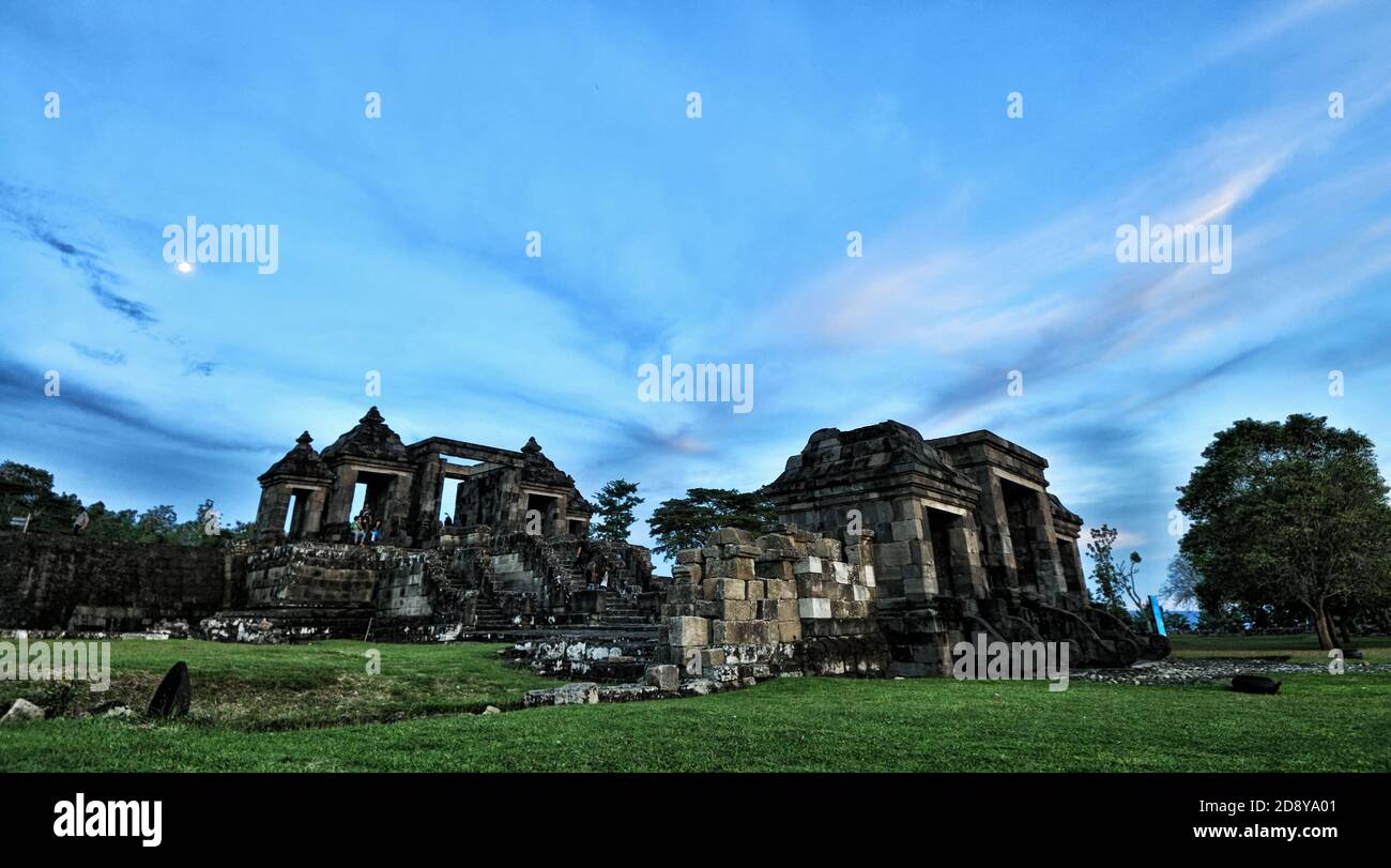 On a hillside plateau, overlooking Prambanan temple complex and with a ...