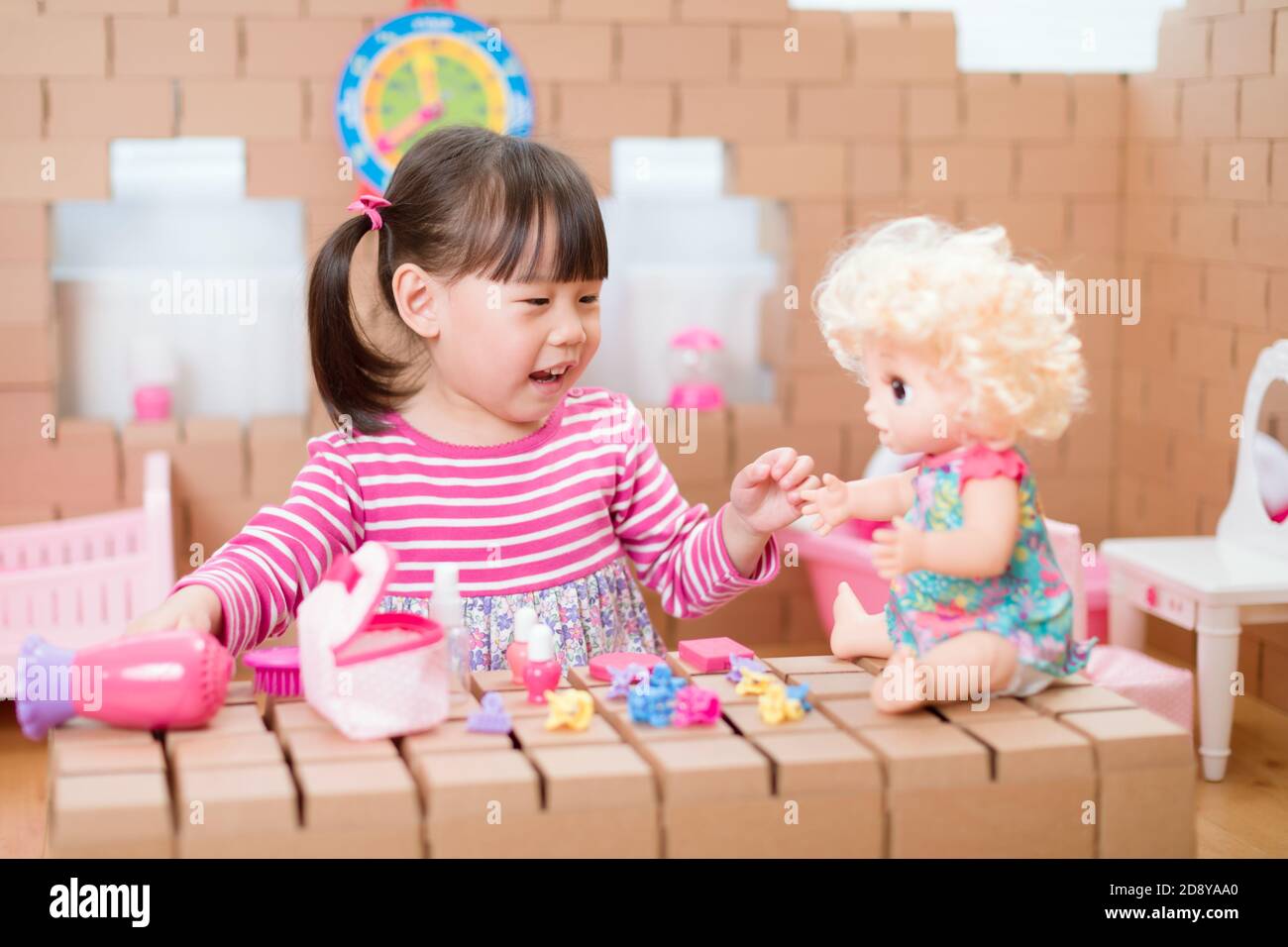 young girl pretend play babysitting with baby doll at home Stock Photo ...