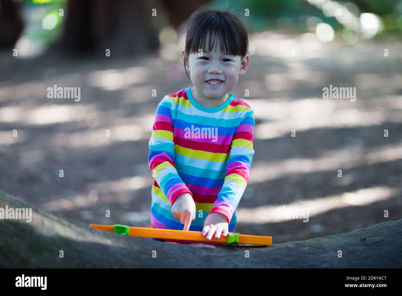 young girl playing outdoor measure-mate in the forest park for leaning ...