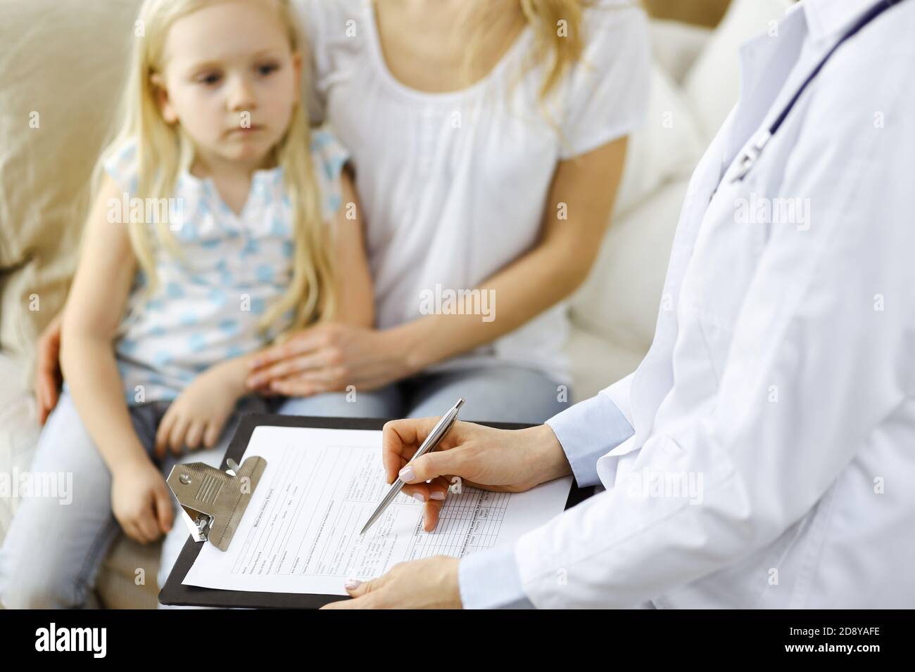 Doctor and patient. Pediatrician using clipboard while examining little ...