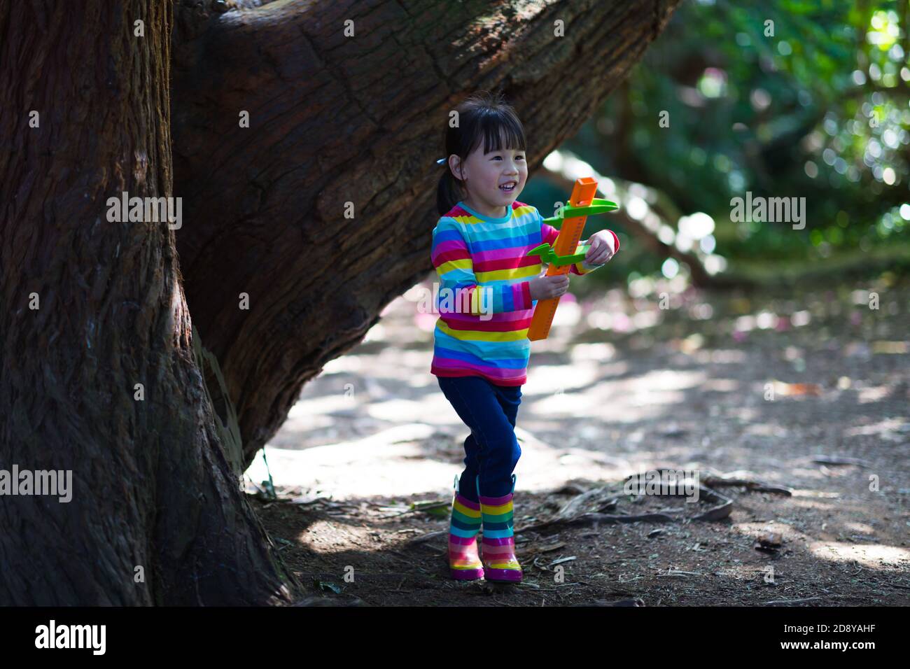 young girl playing outdoor measure-mate in the forest park for leaning ...