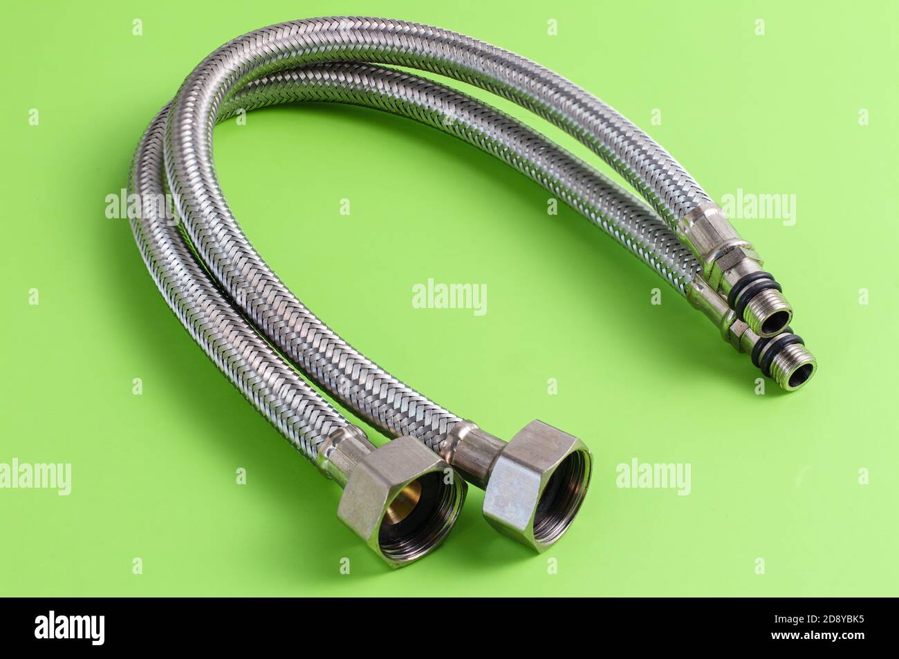 Flexible water pipes in metal braid on green chromakey background Stock ...