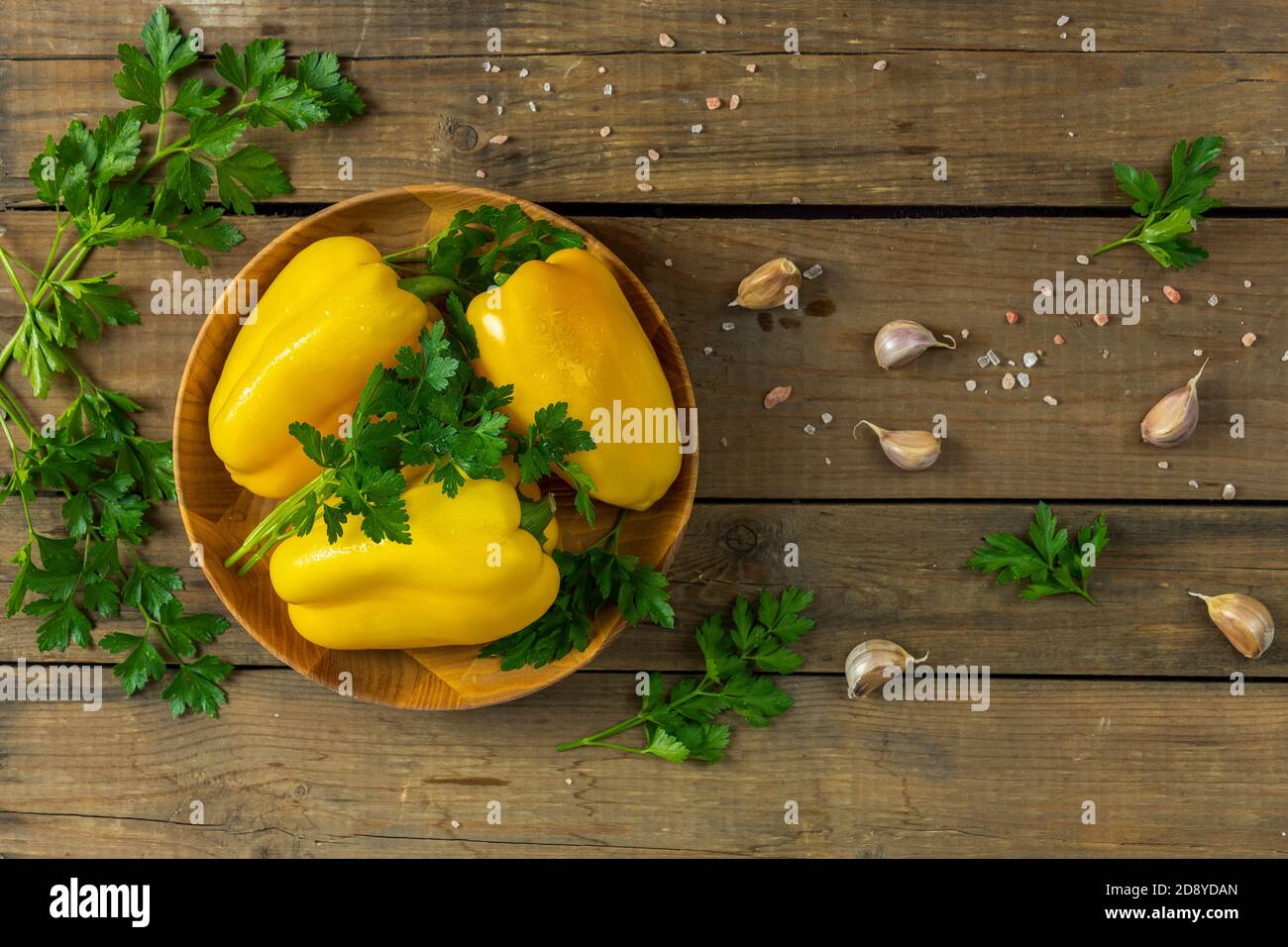 Different raw ripe fresh yellow pepper in wooden plate. Concept of ...