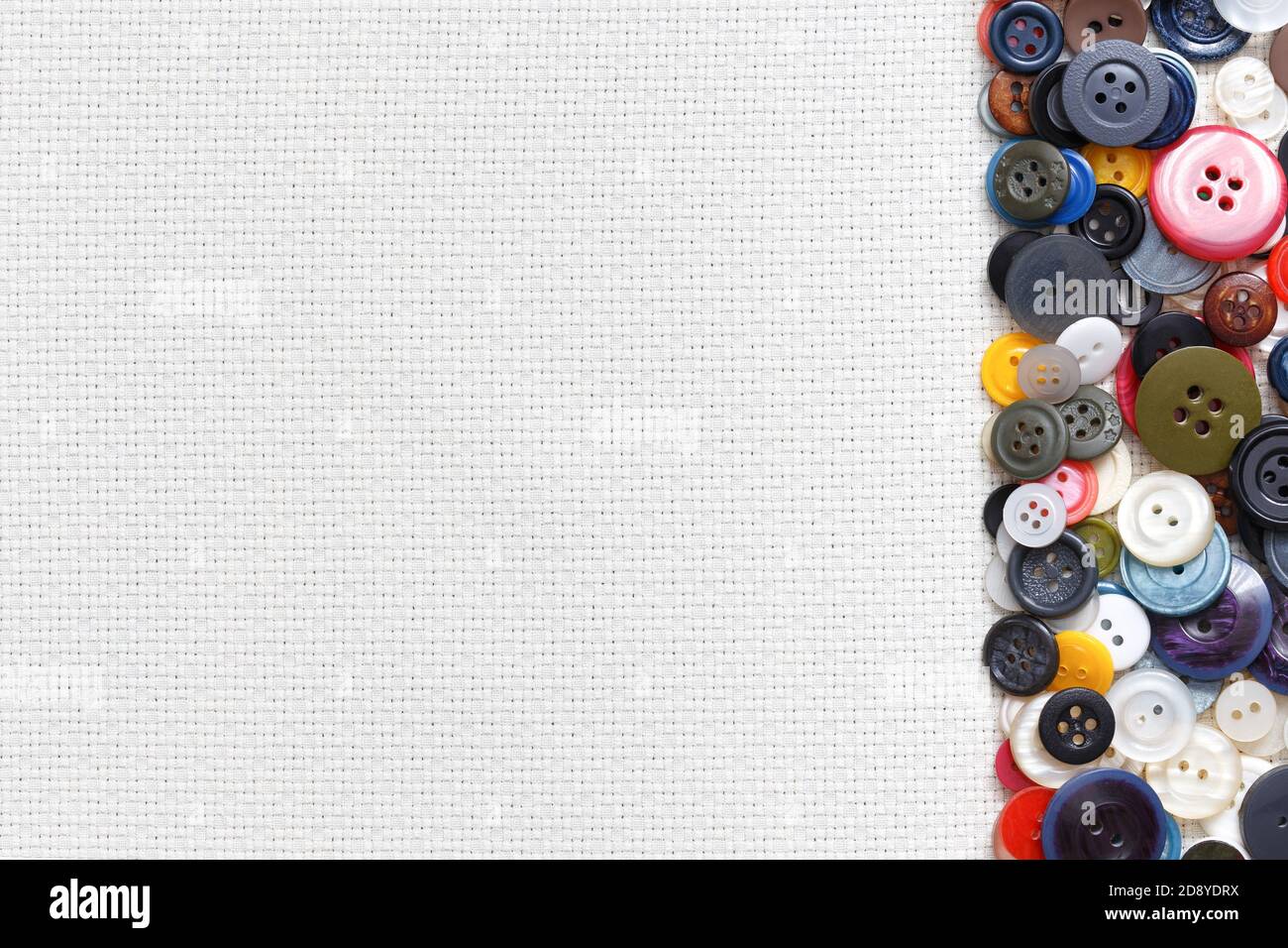 Multi-colored buttons on a white woven background in the form of a ...