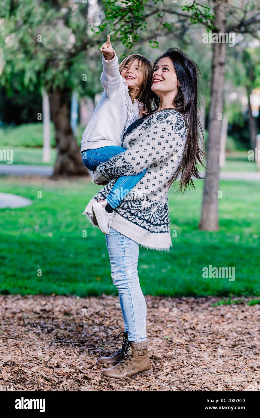 Mother Holding Her Daughter And Playing Around Park On Beautiful