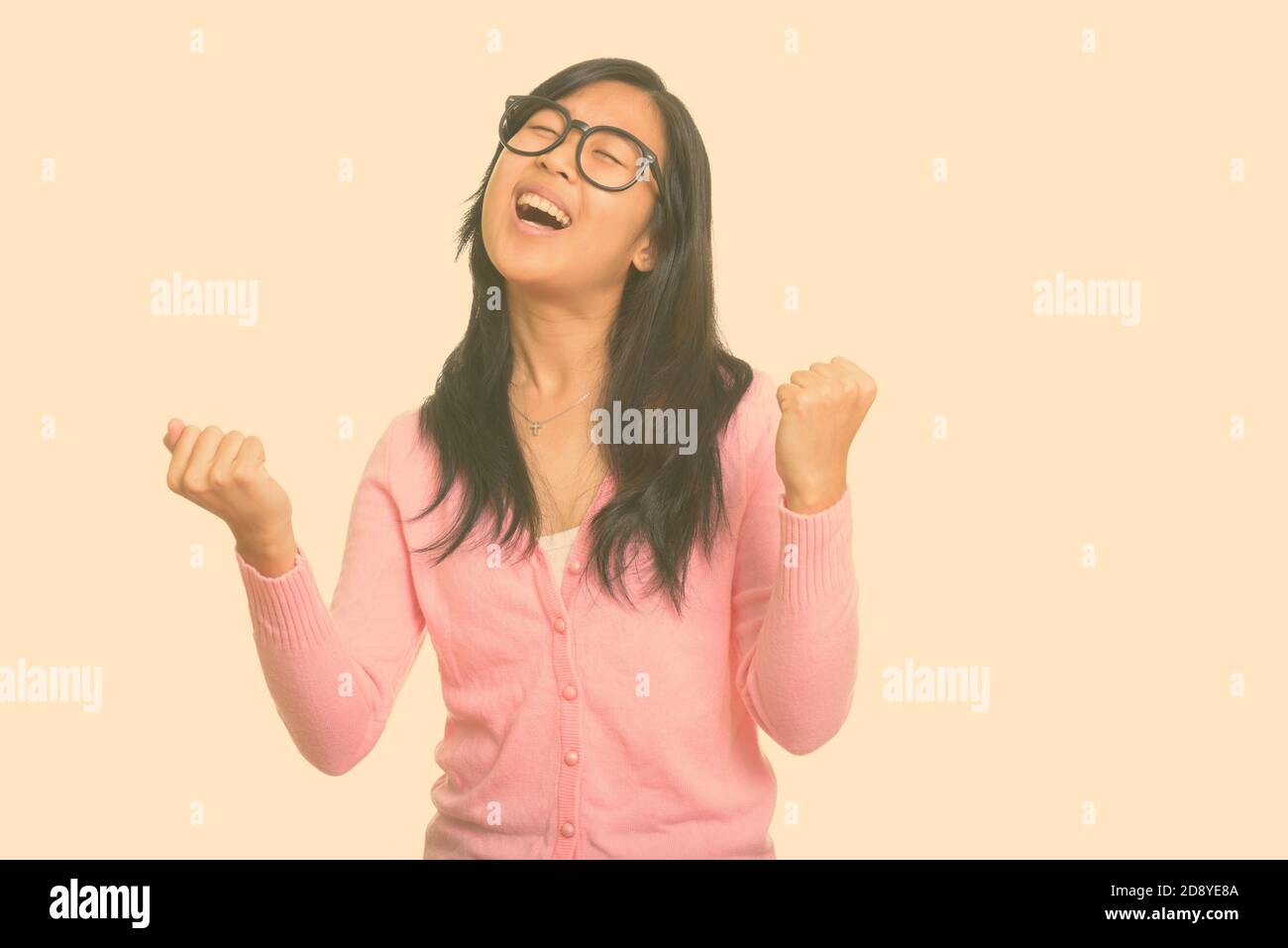 Portrait of happy young beautiful Asian nerd woman getting good news ...