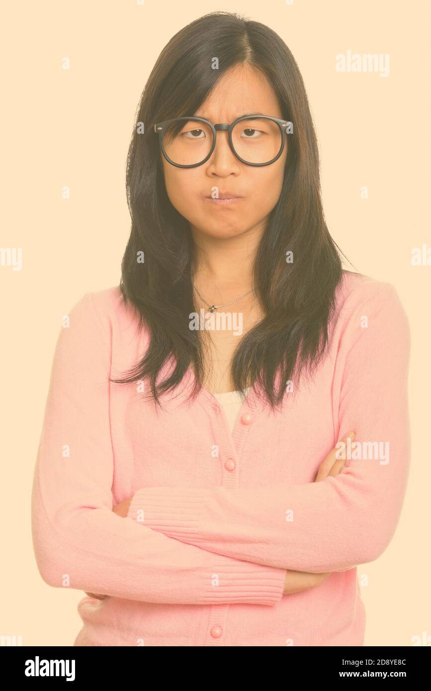Portrait of stressed young Asian nerd woman looking angry with arms ...