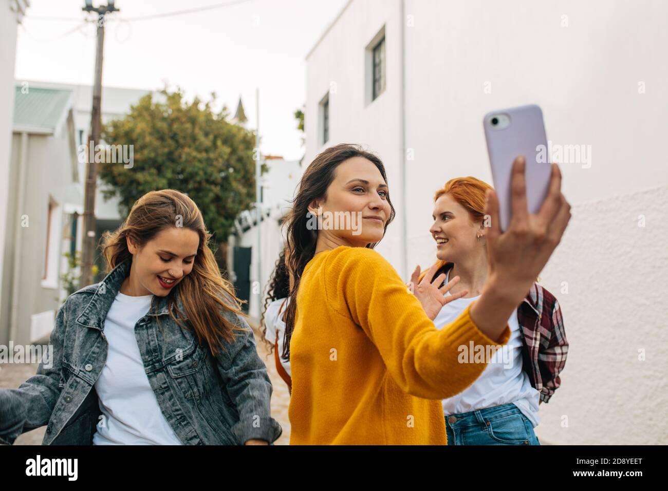 Group of women enjoying dancing on the street and taking a selfie ...