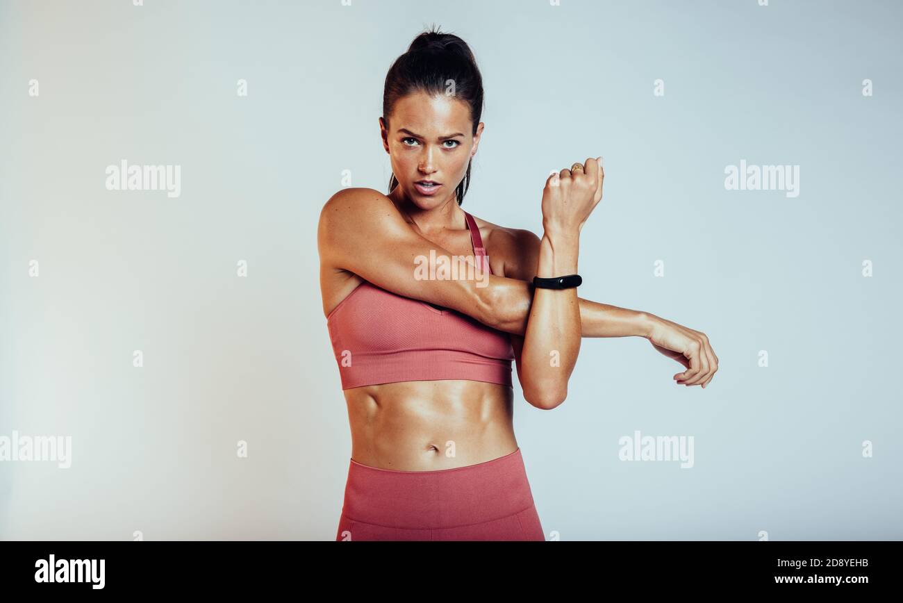 Portrait of determined female athlete doing workout on white background ...
