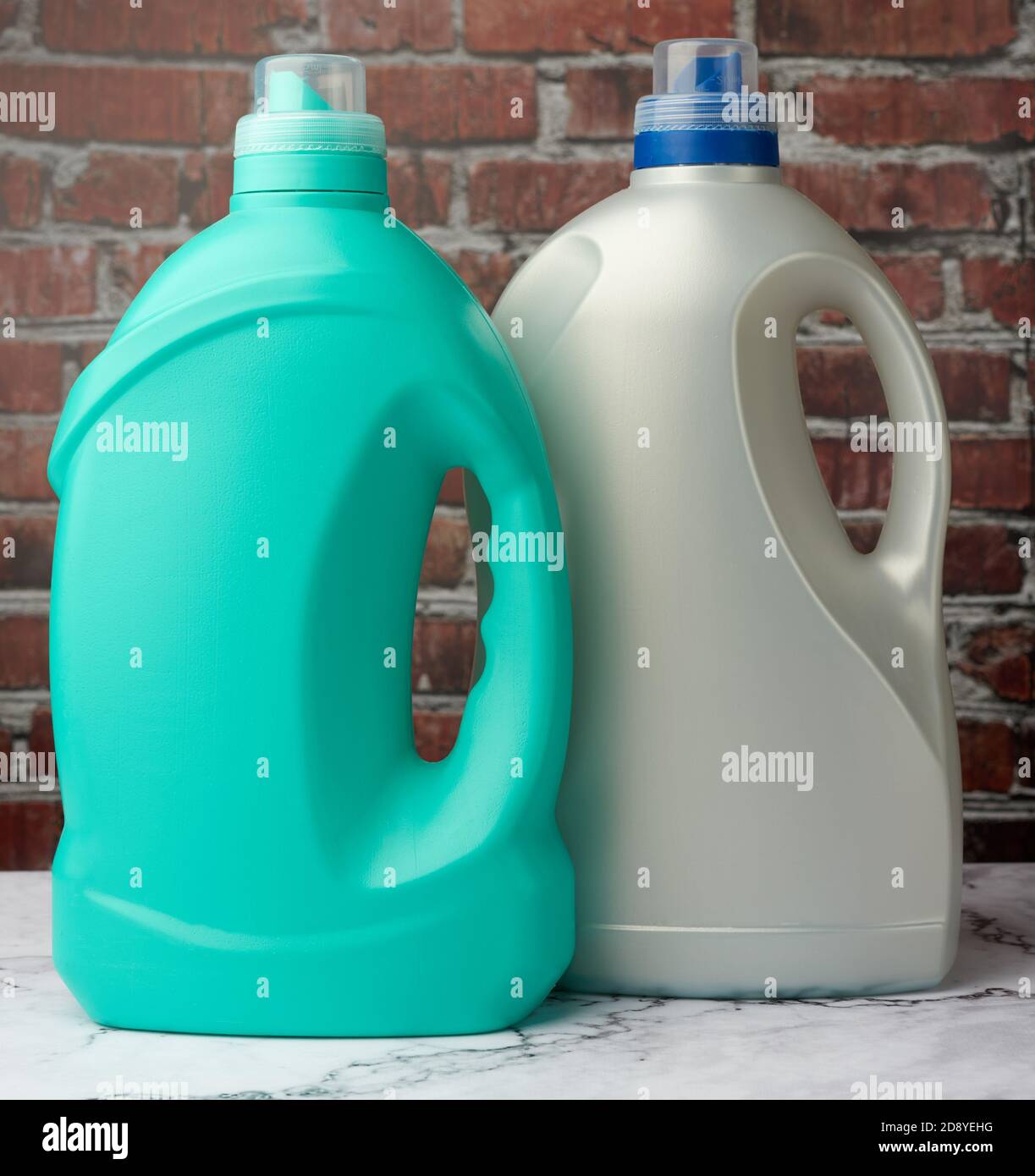 large plastic bottles with liquid detergent on a brown brick wall ...