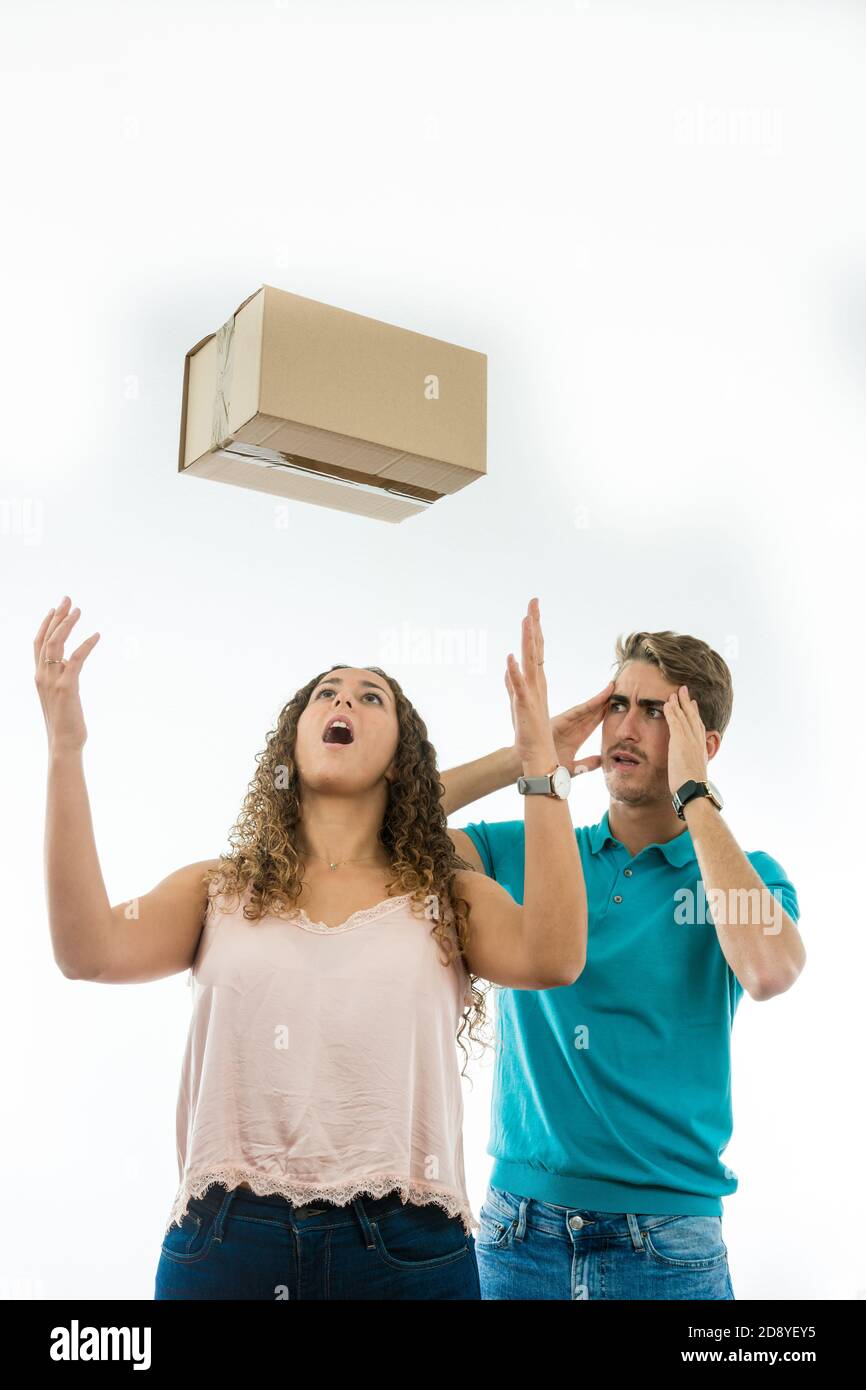 Couple throwing cardboard boxes high, happy and surprised by what's ...