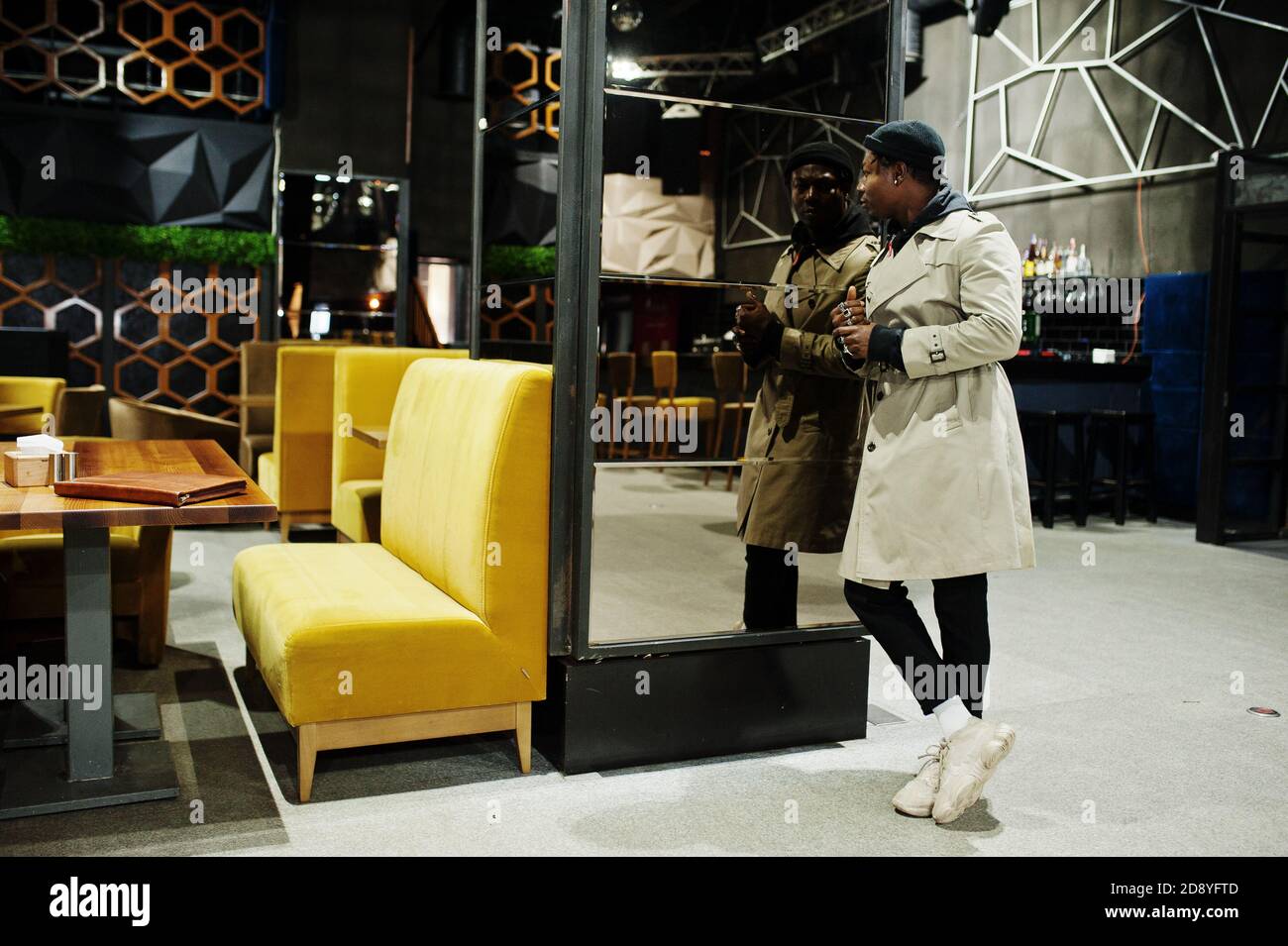 Handsome african american man posing inside night club in black hat and ...