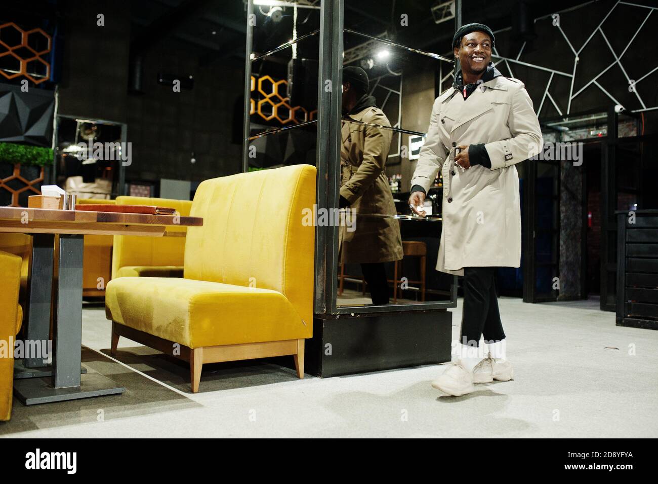 Handsome african american man posing inside night club in black hat and ...