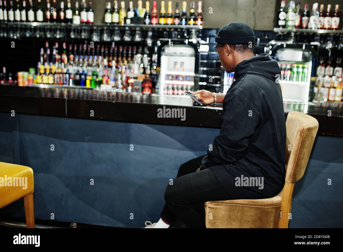 Handsome african american man posing inside night club in black hat ...