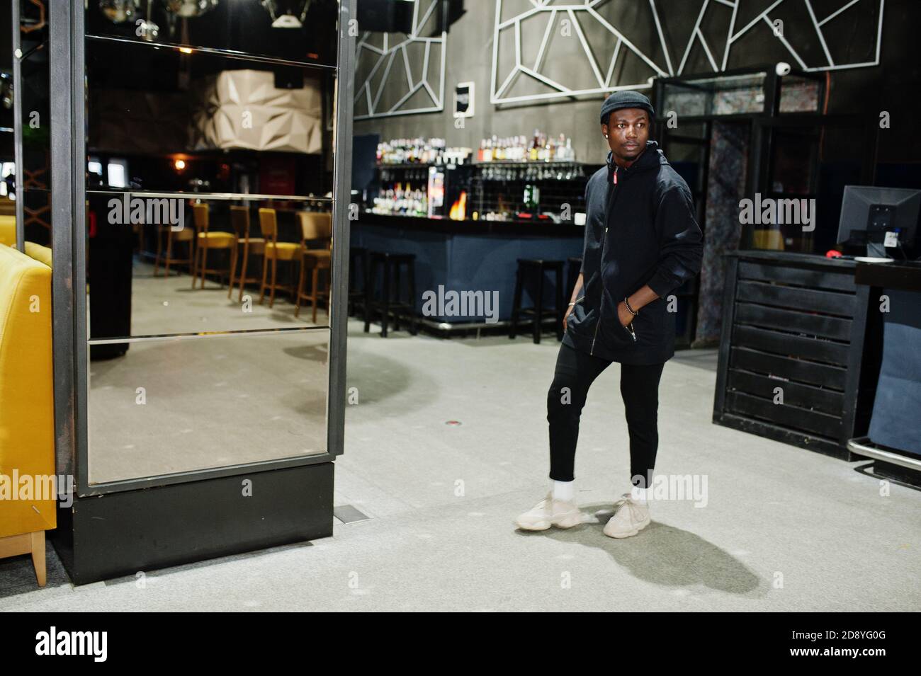 Handsome african american man posing inside night club in black hat ...
