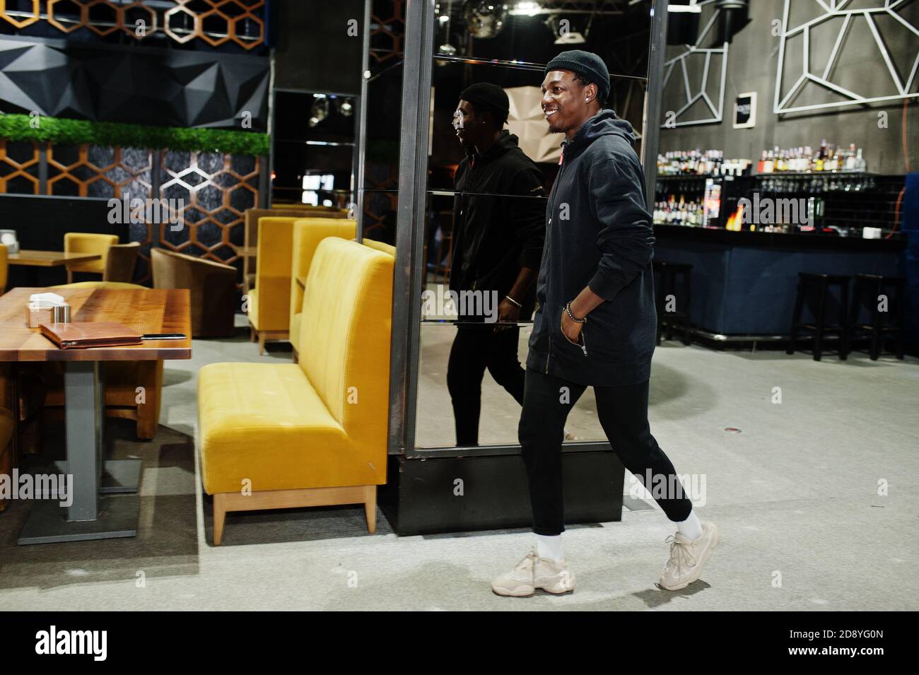 Handsome african american man posing inside night club in black hat ...
