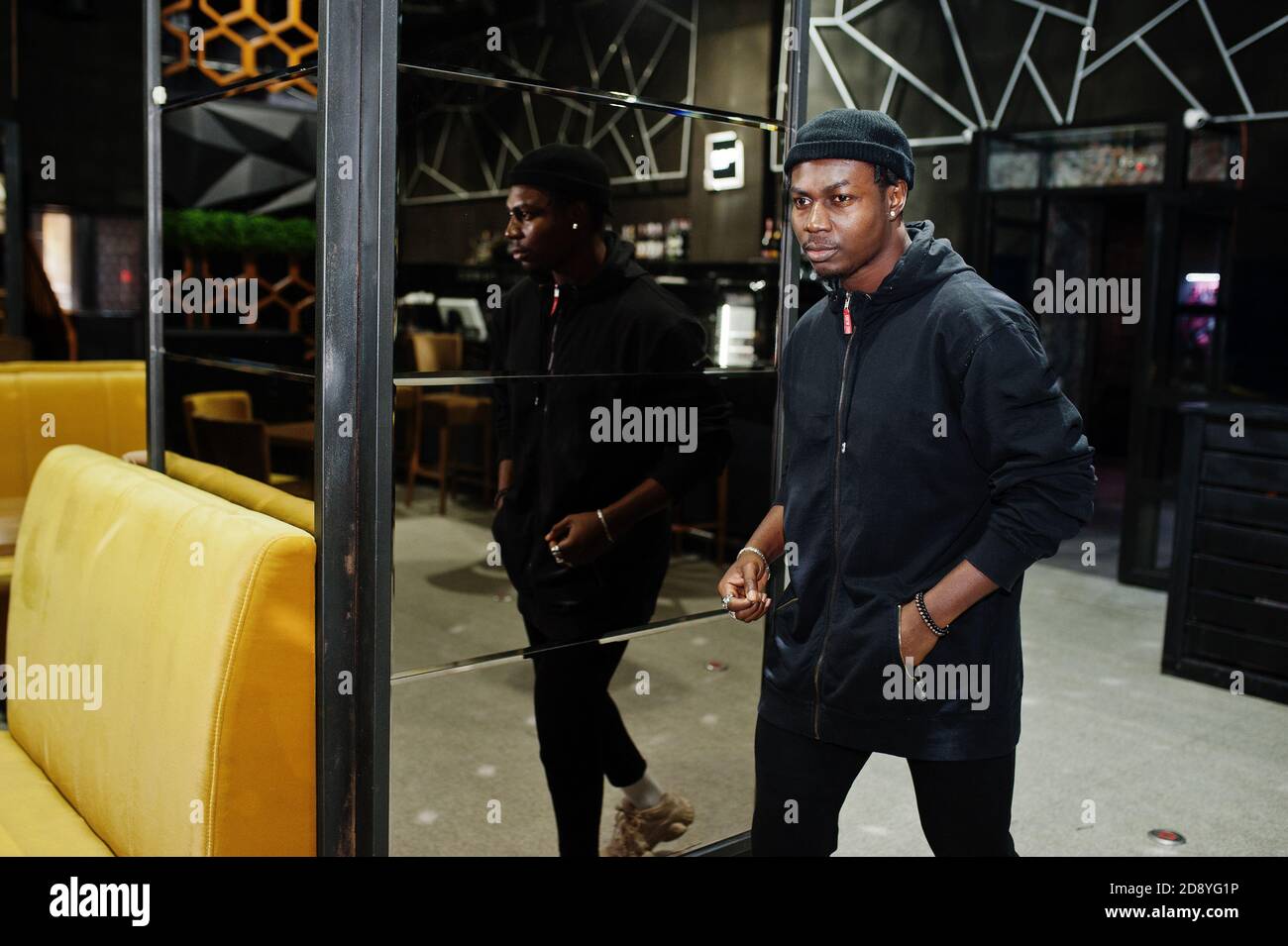 Handsome african american man posing inside night club in black hat ...