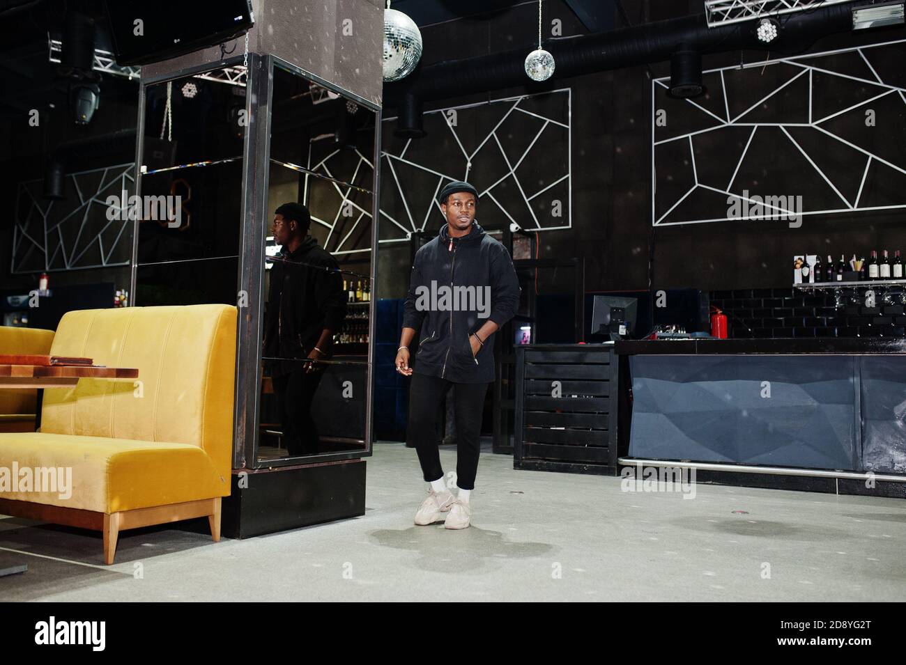 Handsome african american man posing inside night club in black hat ...