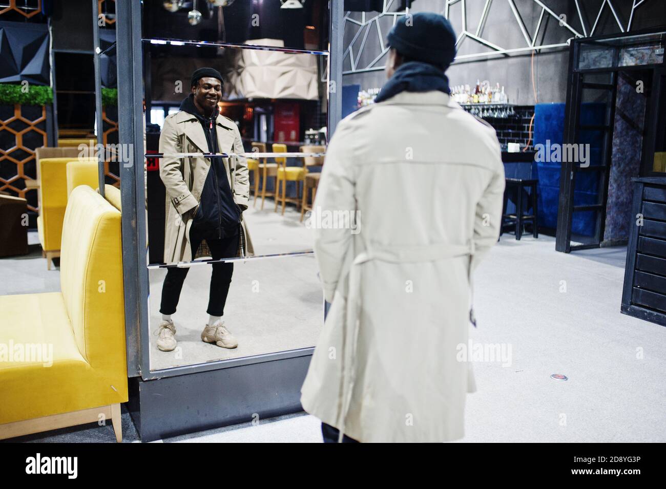 Handsome african american man posing inside night club in black hat and ...