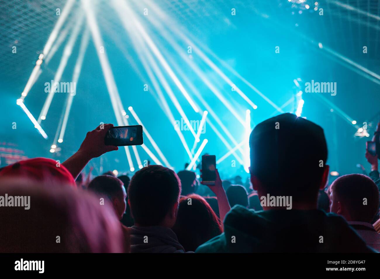 A crowd of people at the concert have fun and dance to the music at the ...