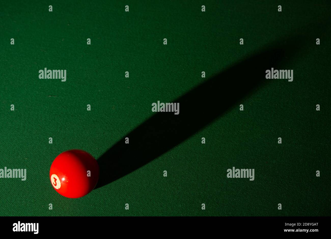 One billiard ball casts a long black shadow on the table surface Stock ...