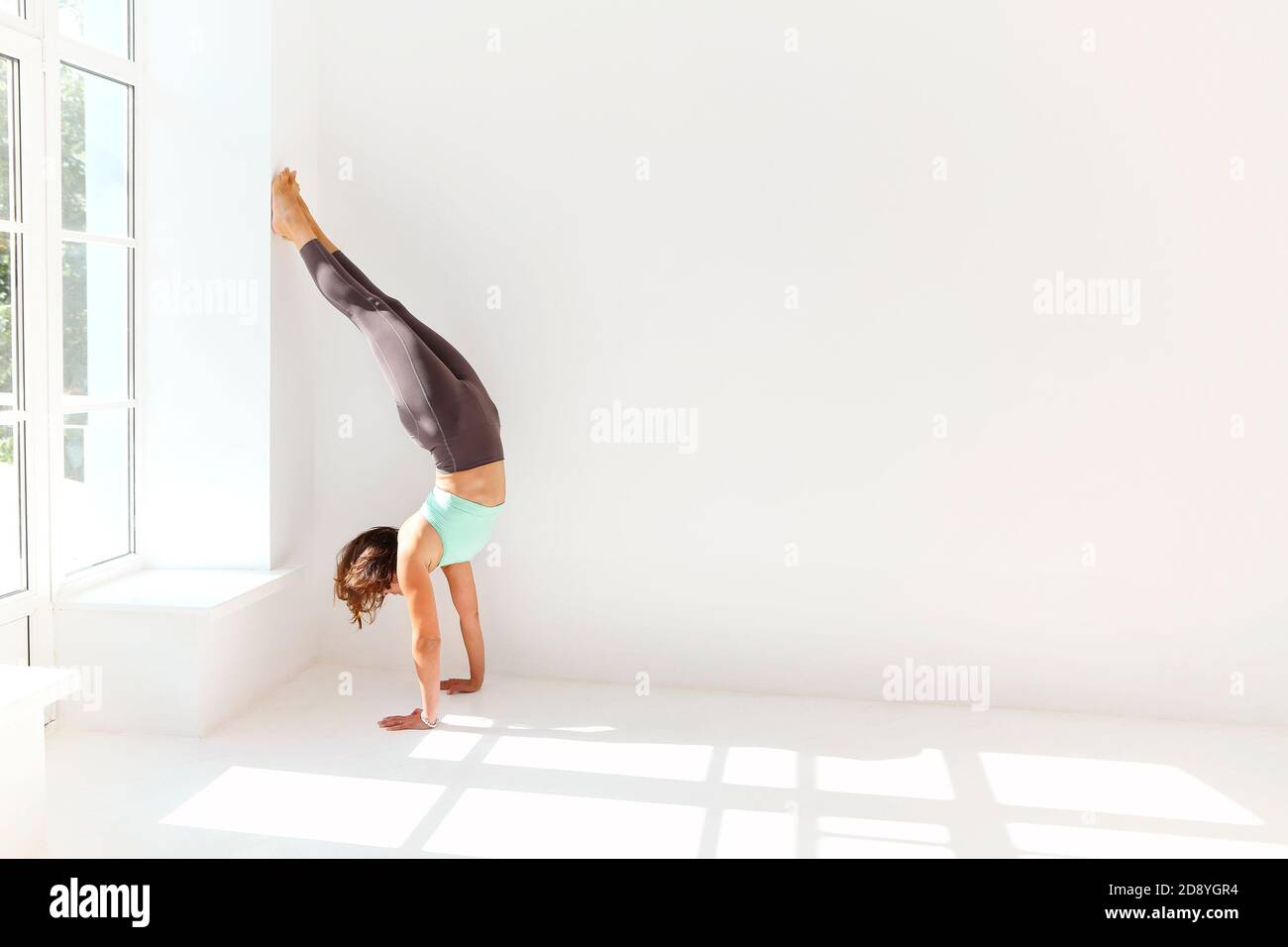 Side view of calm female in sportswear practicing yoga in Firefly pose ...