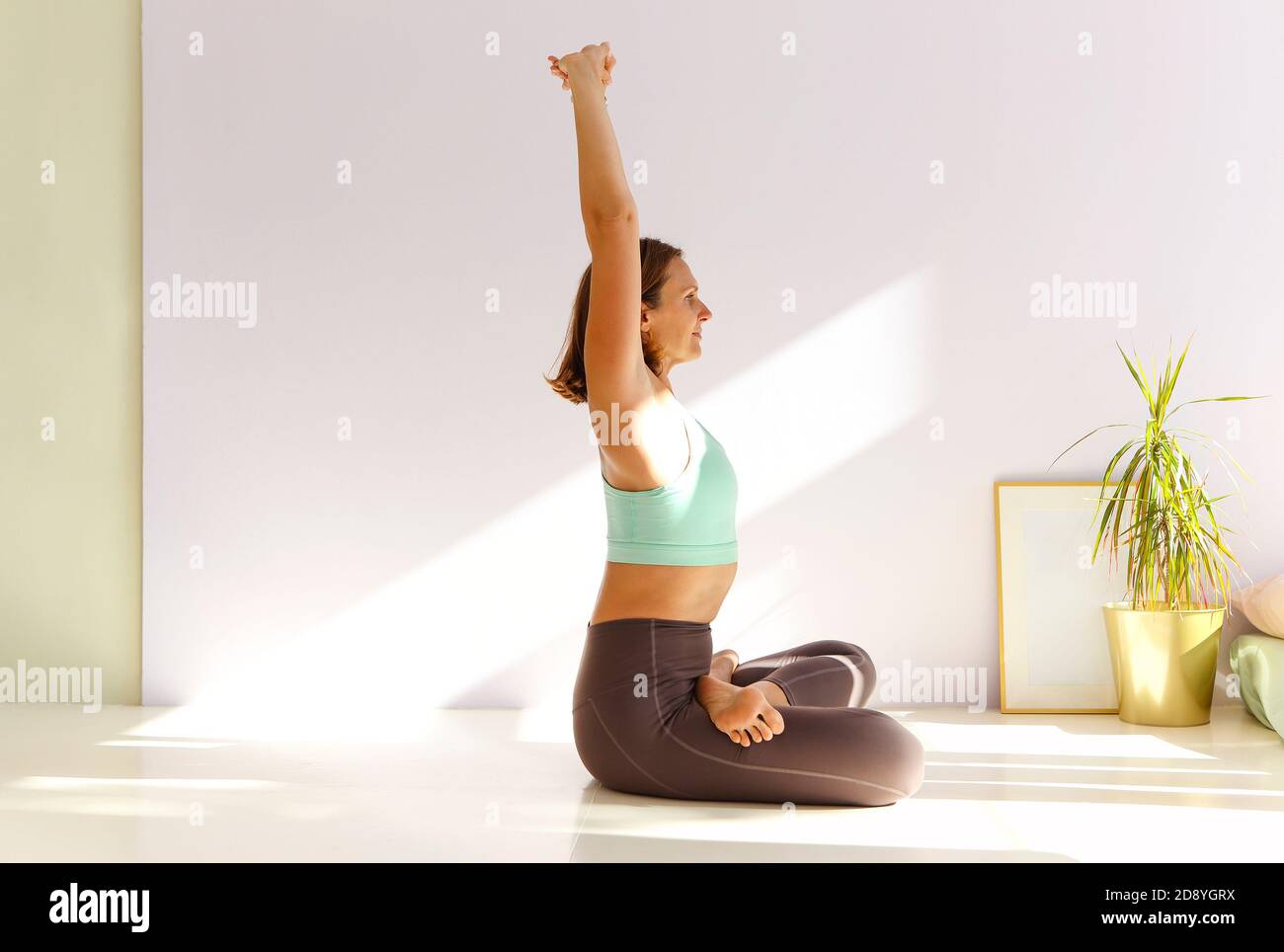Side view of calm female in sportswear practicing yoga in Firefly pose ...