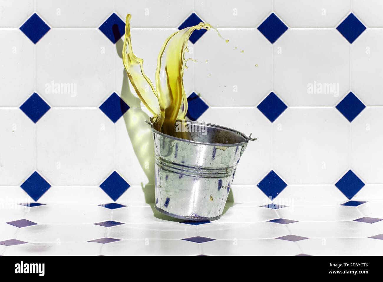 A metal bucket falls to the floor and splashes out the colored liquid ...