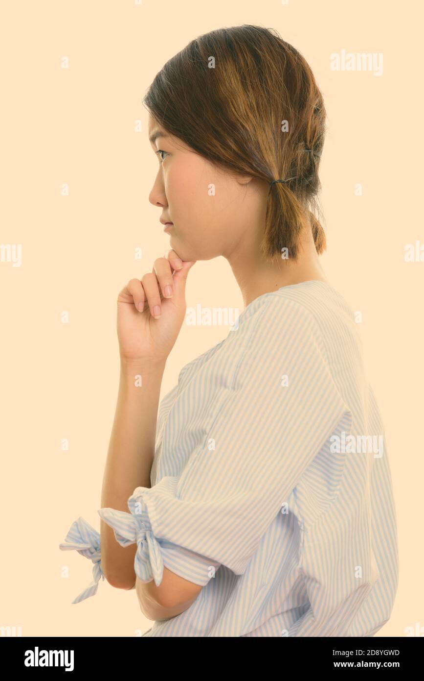 Profile view of young beautiful Asian woman thinking Stock Photo - Alamy