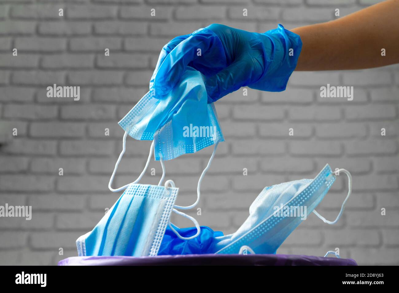 Hand putting used dirty surgical mask to a garbage bin Stock Photo - Alamy