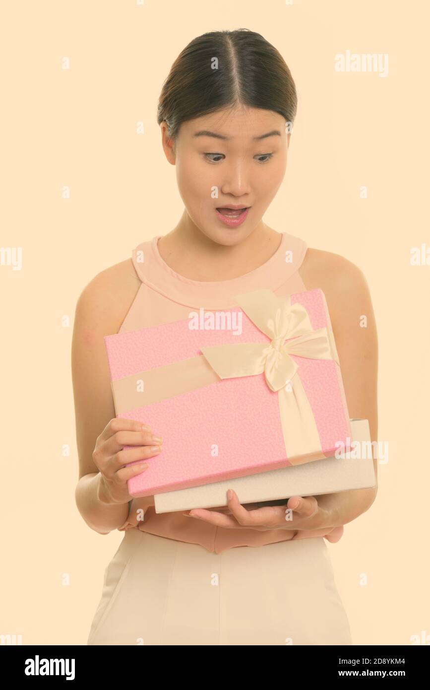 Young beautiful Asian woman opening gift box while looking surprised ...