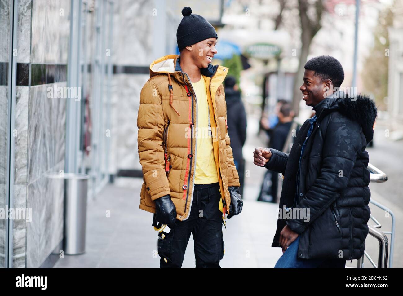 Two african male friends talking together, wear on jackets at cold ...